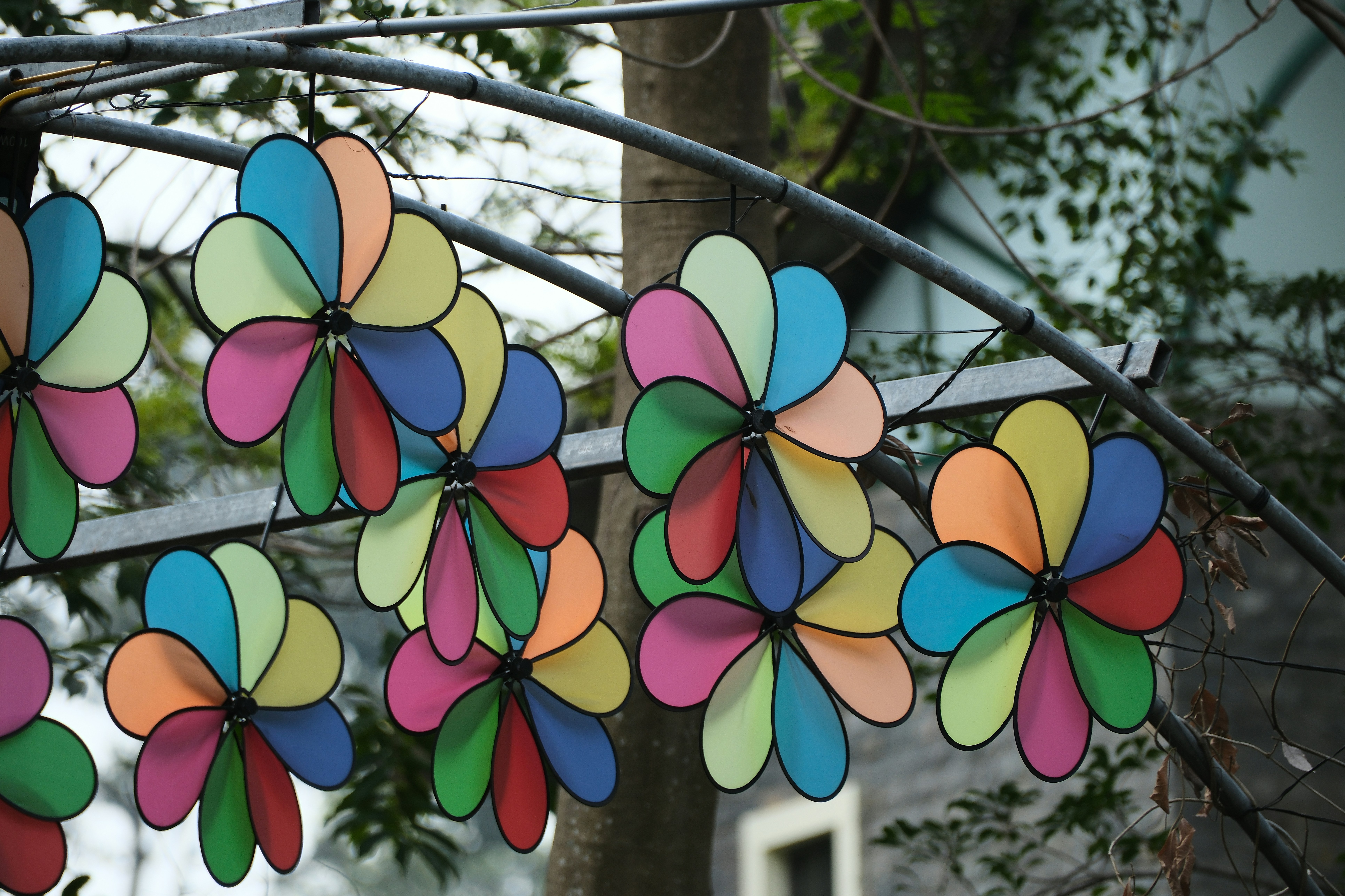 A bunch of colorful paper flowers hanging from a tree