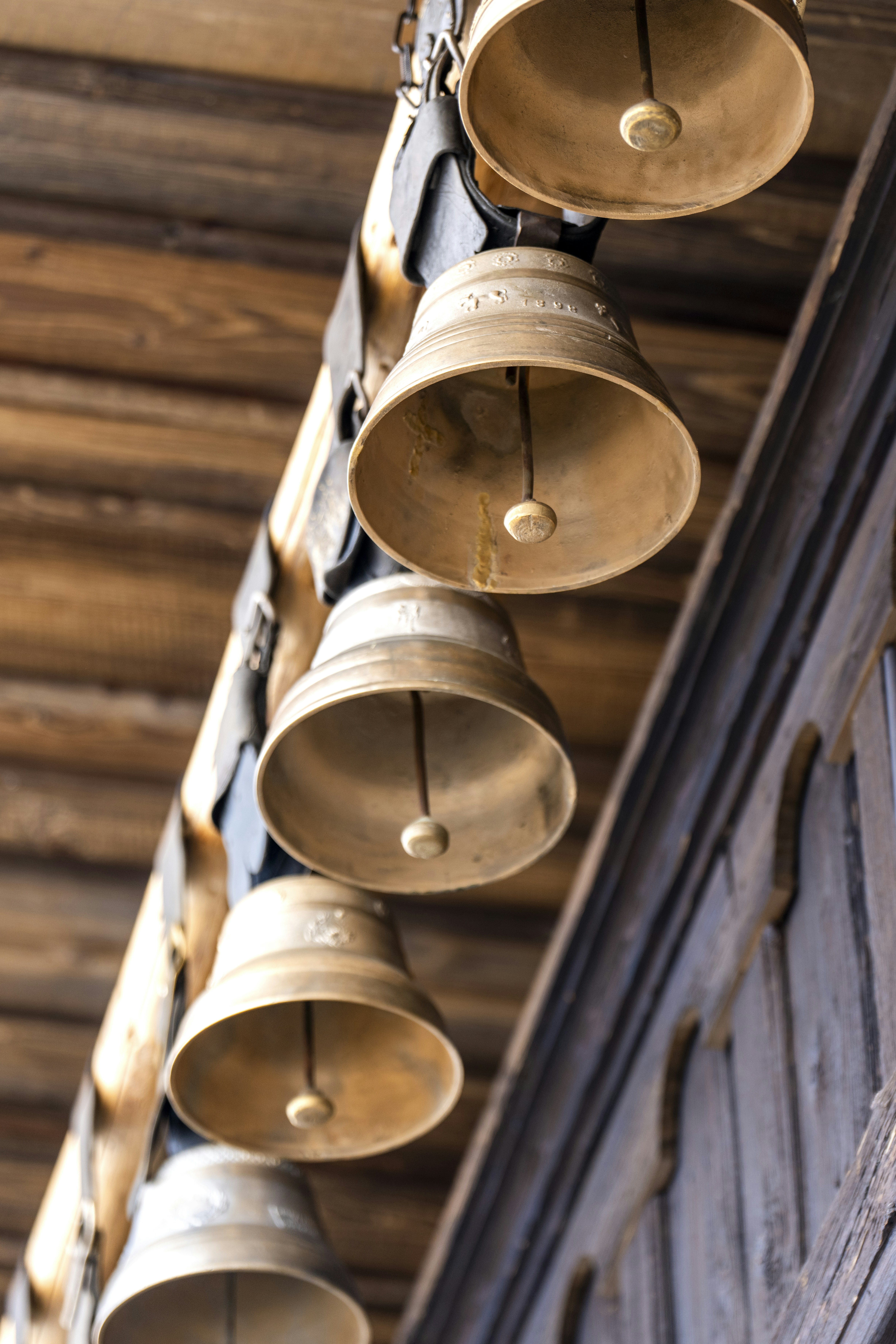 A bunch of bells hanging from the side of a building photo – Free ...