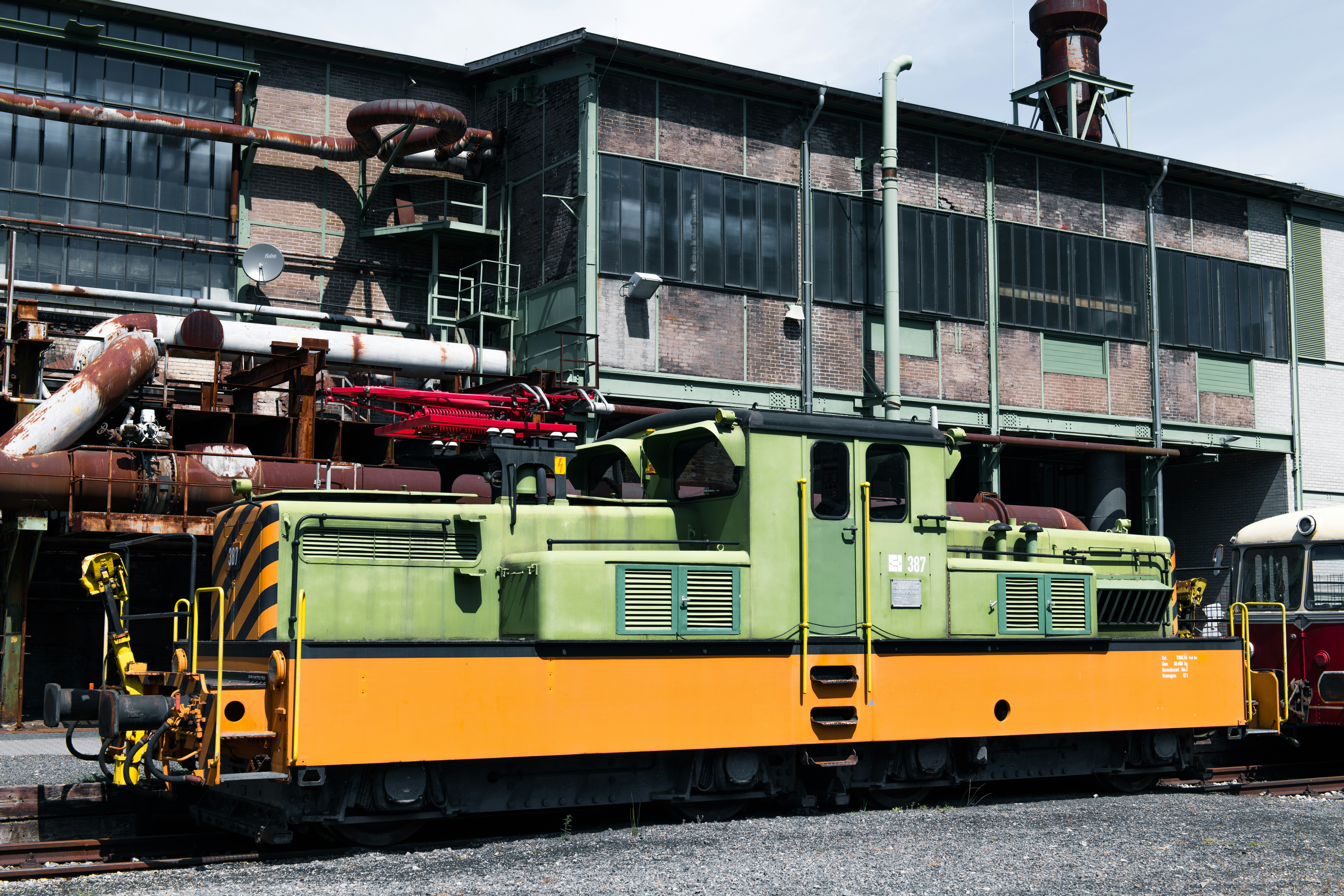 Lime-Green Shunter Rests Against a Weathered Brick Factory