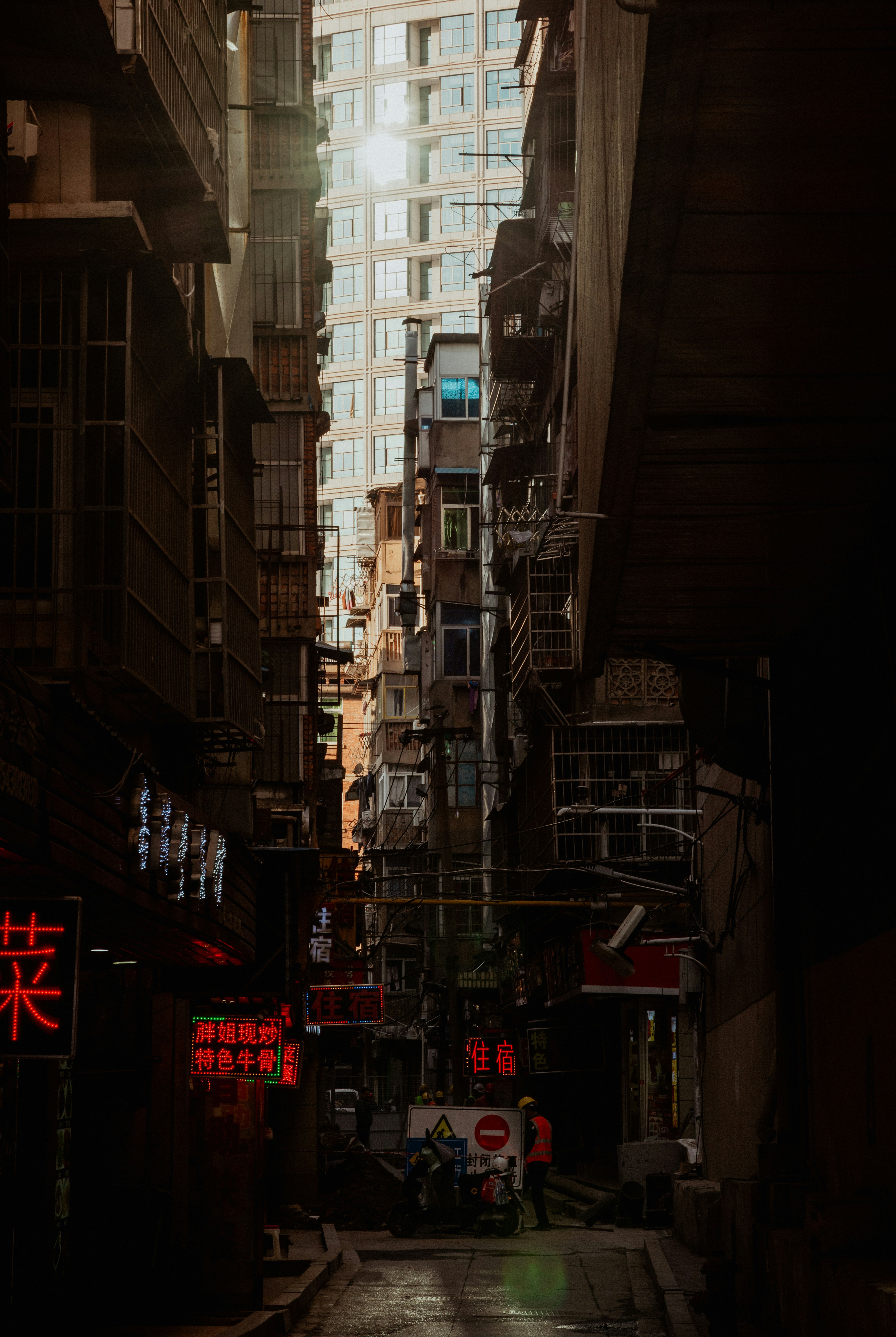 A narrow city street with buildings and signs photo – Free Alley Image ...
