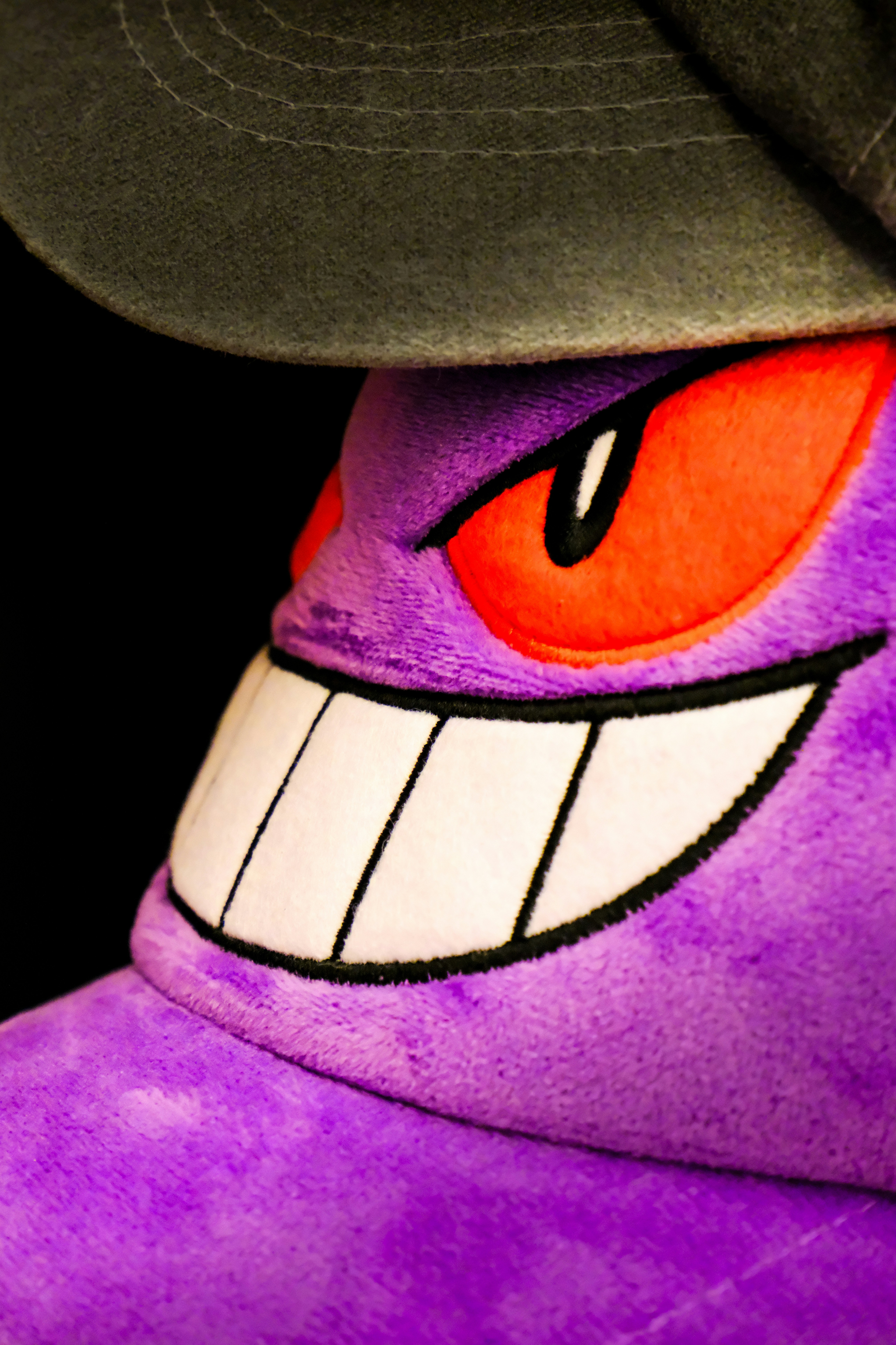 Beneath the Hat: A Purple Plush with a Mischievous Grin