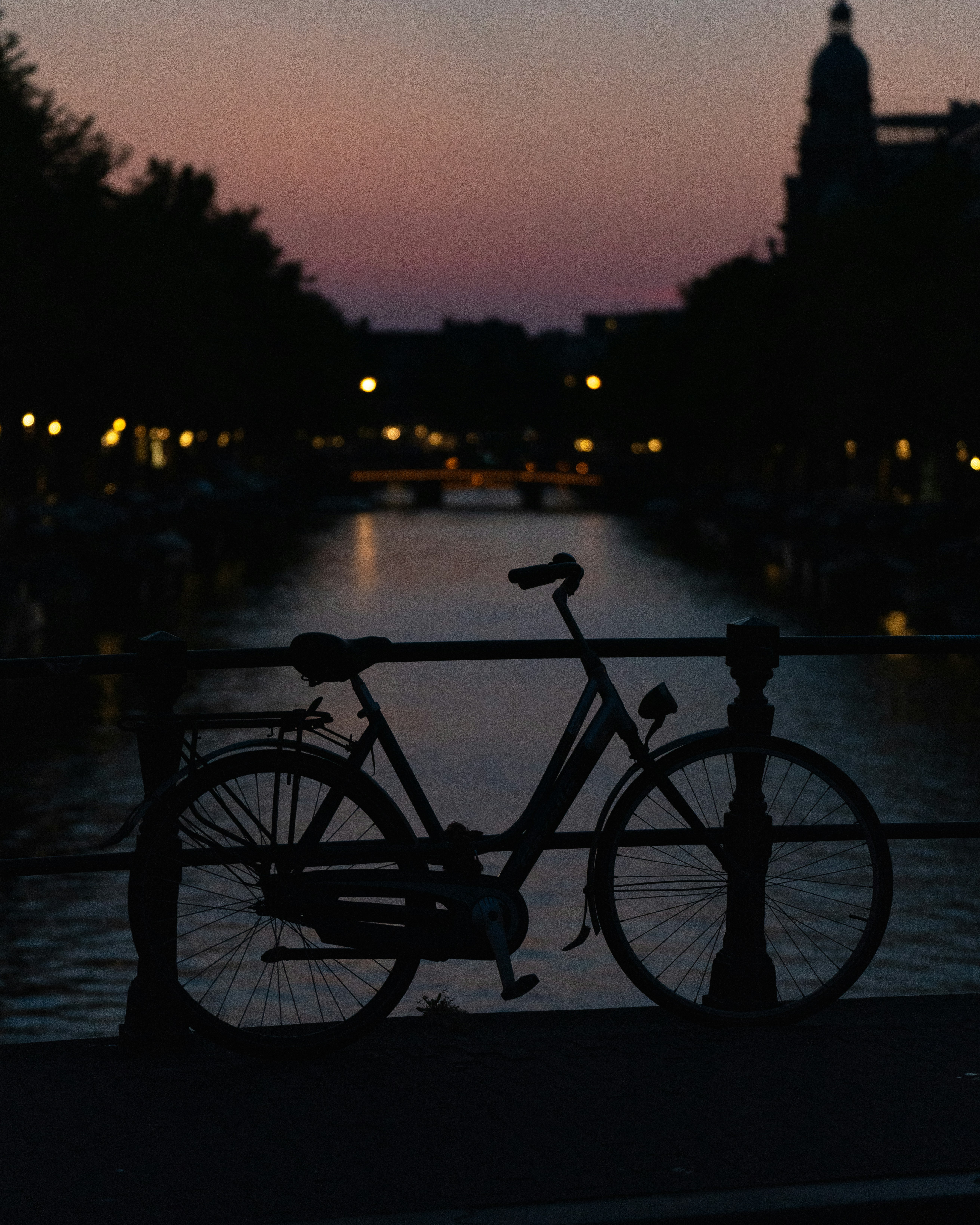 Dusk on Wheels: Bicycle Silhouette by the Quiet Canal