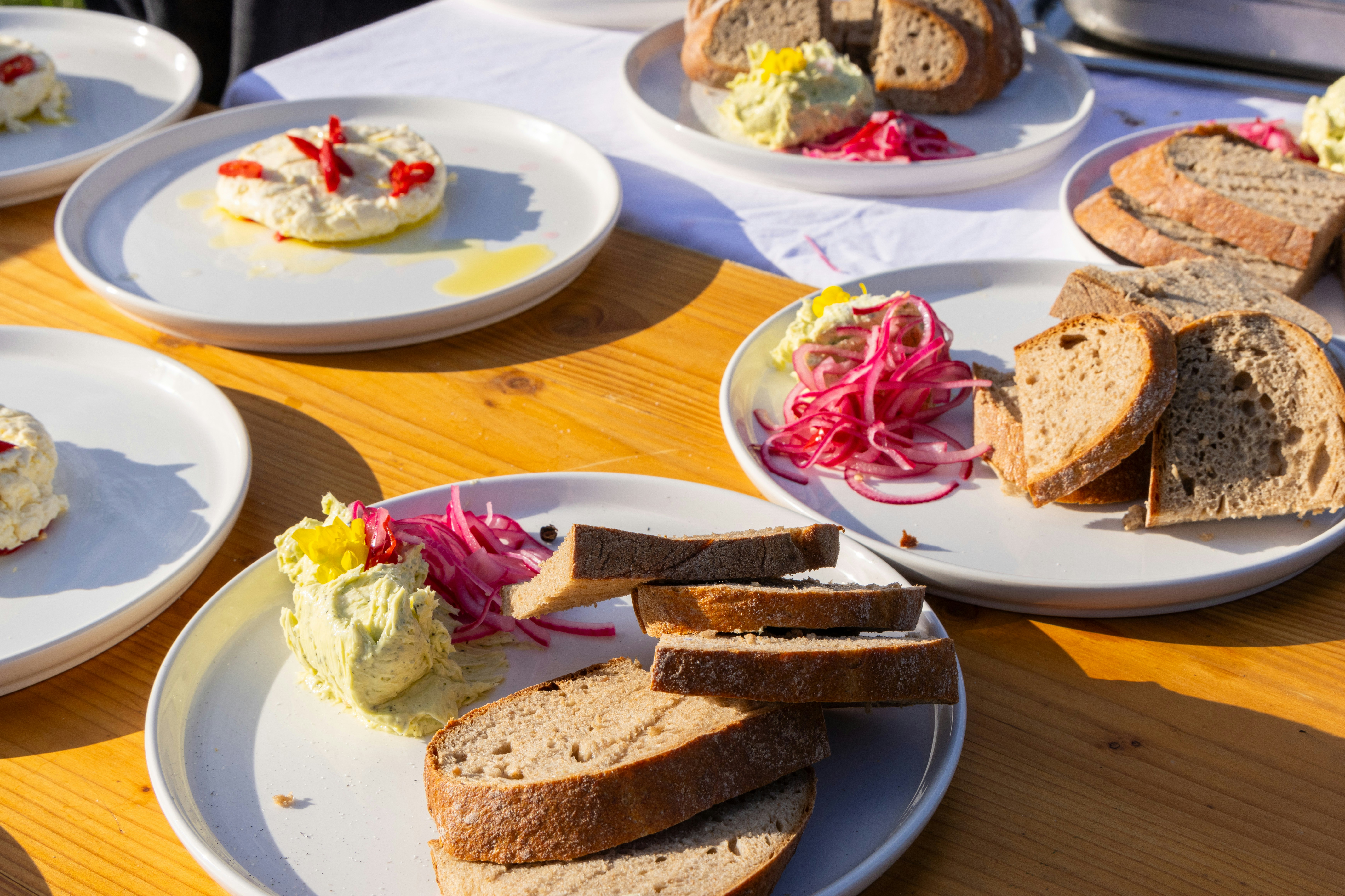 A table topped with white plates filled with food photo – Free Organic ...
