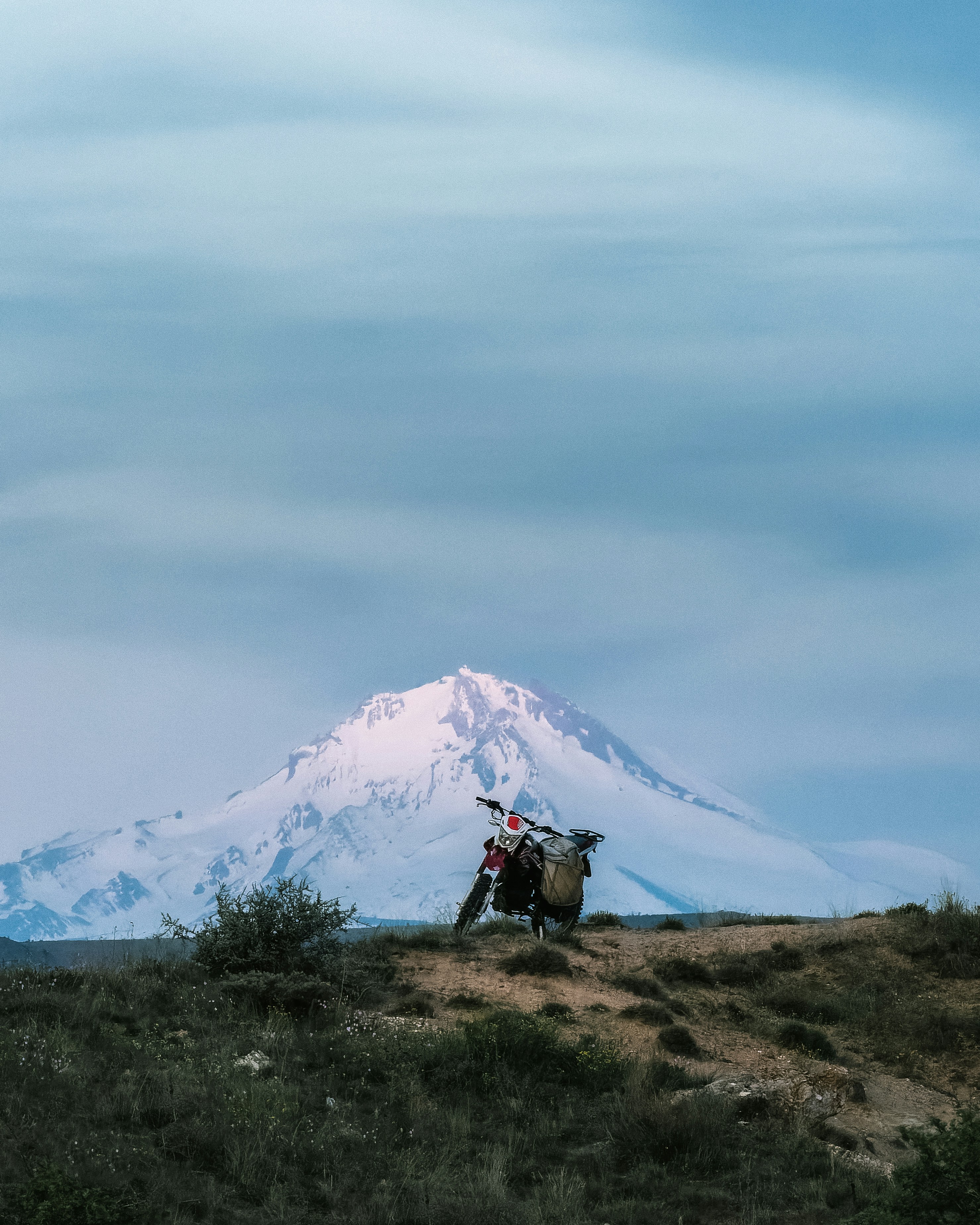 Trailhead at Snowbound Peak: A Motorcycle Framed by a Majestic Summit