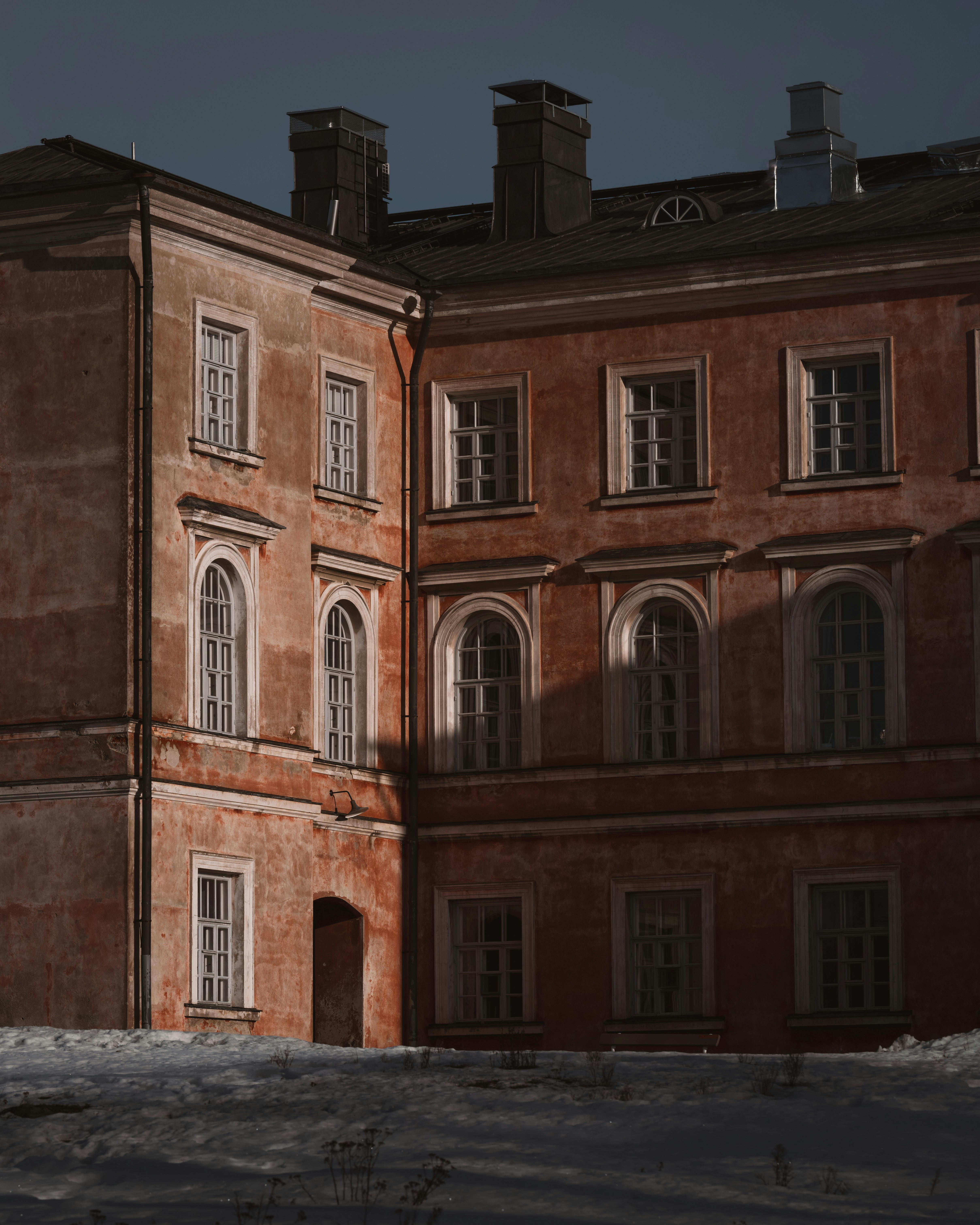 Sunlit Facade, Rueful Shadows: A Historic Brick House in Soft Evening Light
