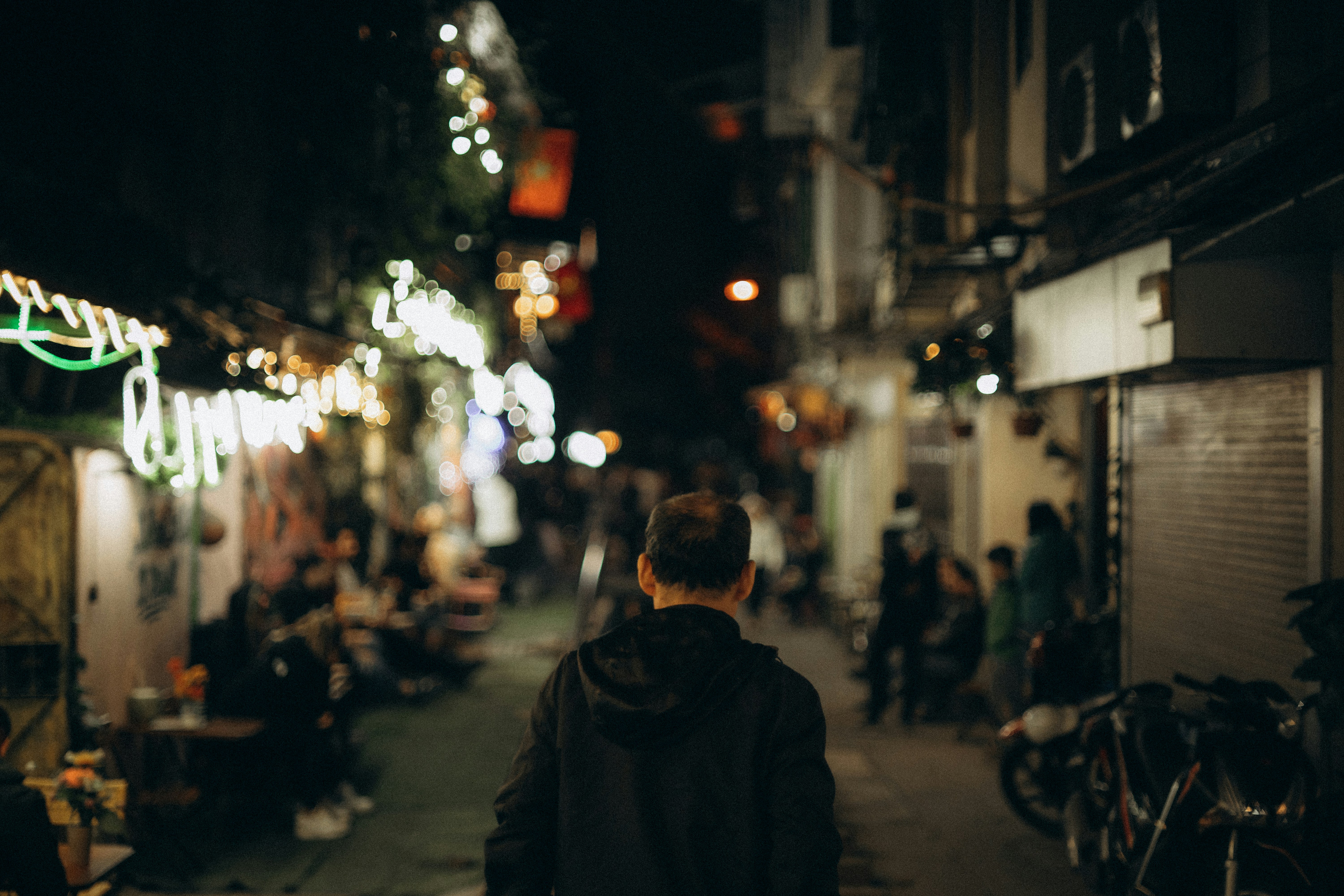 Um homem andando por uma rua à noite foto – Imagem grátis sobre Cidade ...