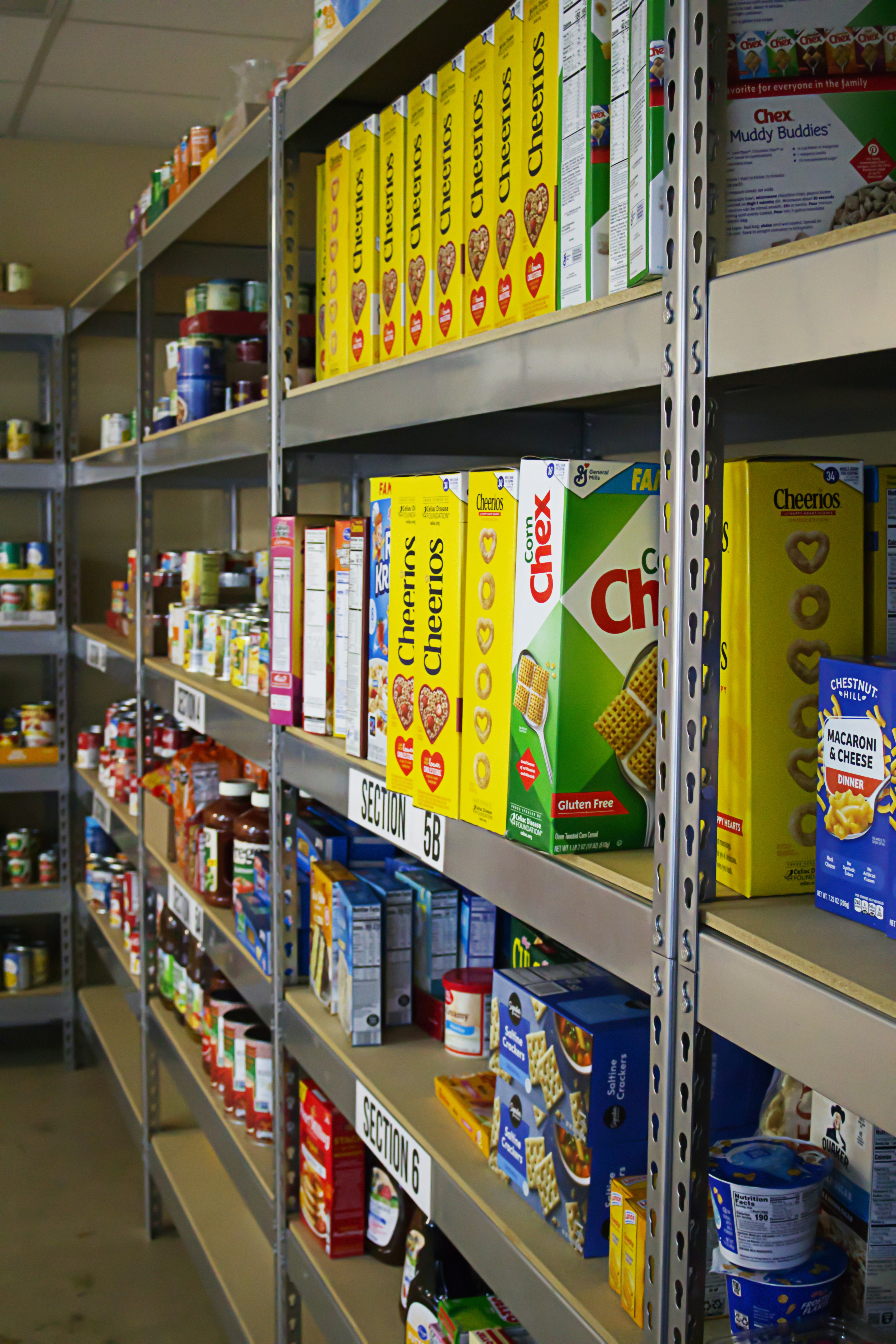 Organized shelves filled with various food items in a community pantry, showcasing available groceries for those in need.