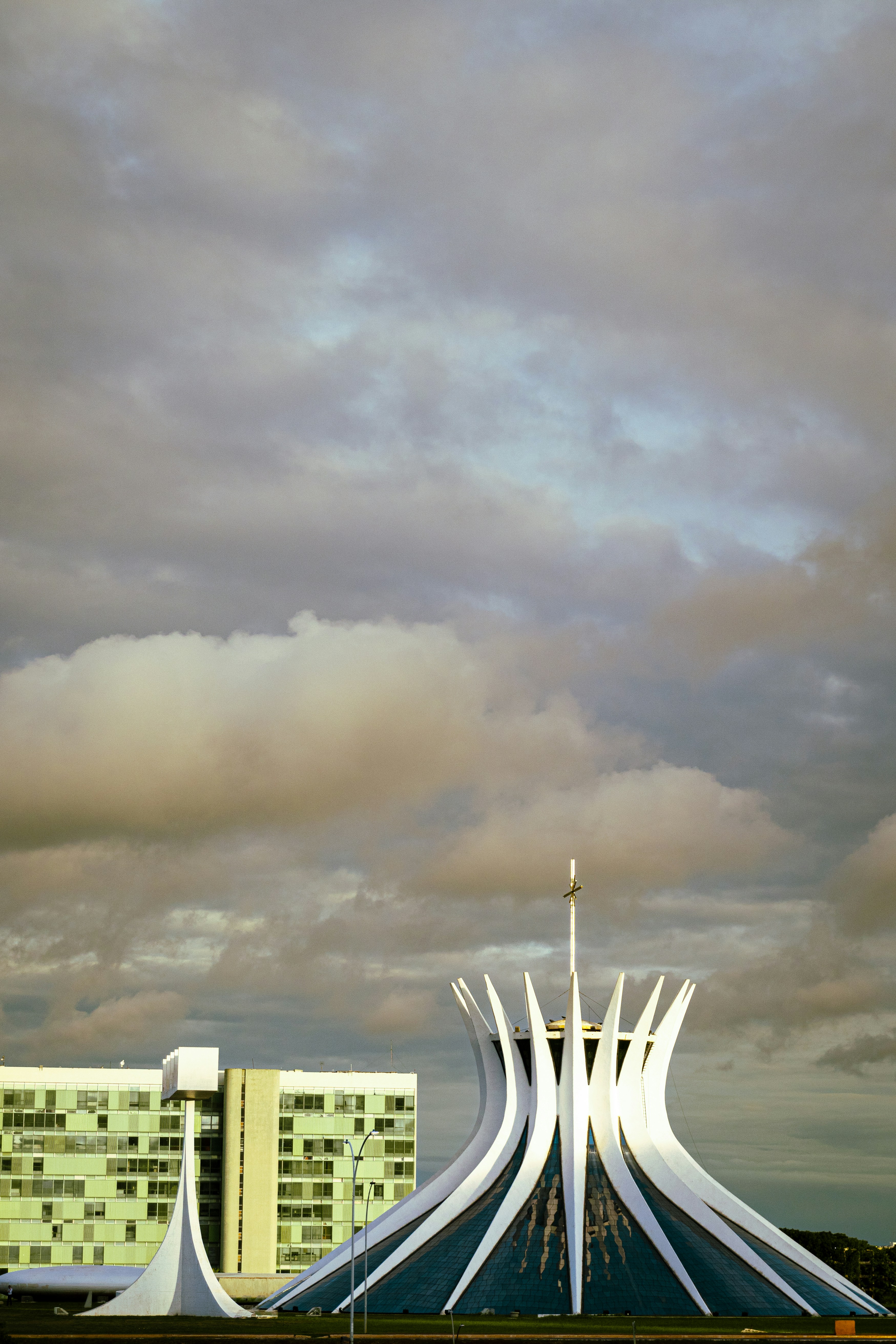 Modern cathedral architecture with white spires against a backdrop of cloudy skies.