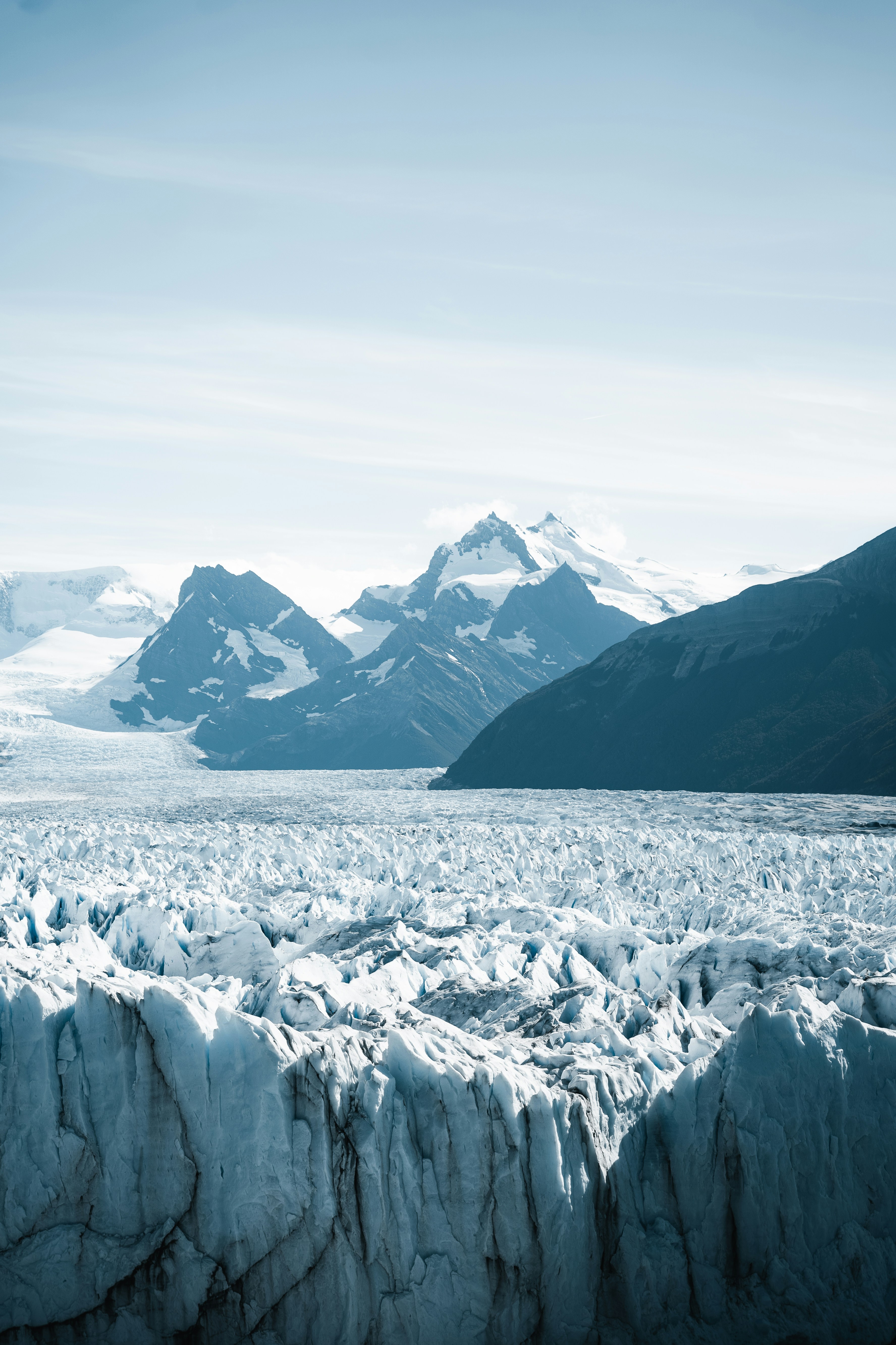 A large glacier with mountains in the background photo – Free Wallpaper ...