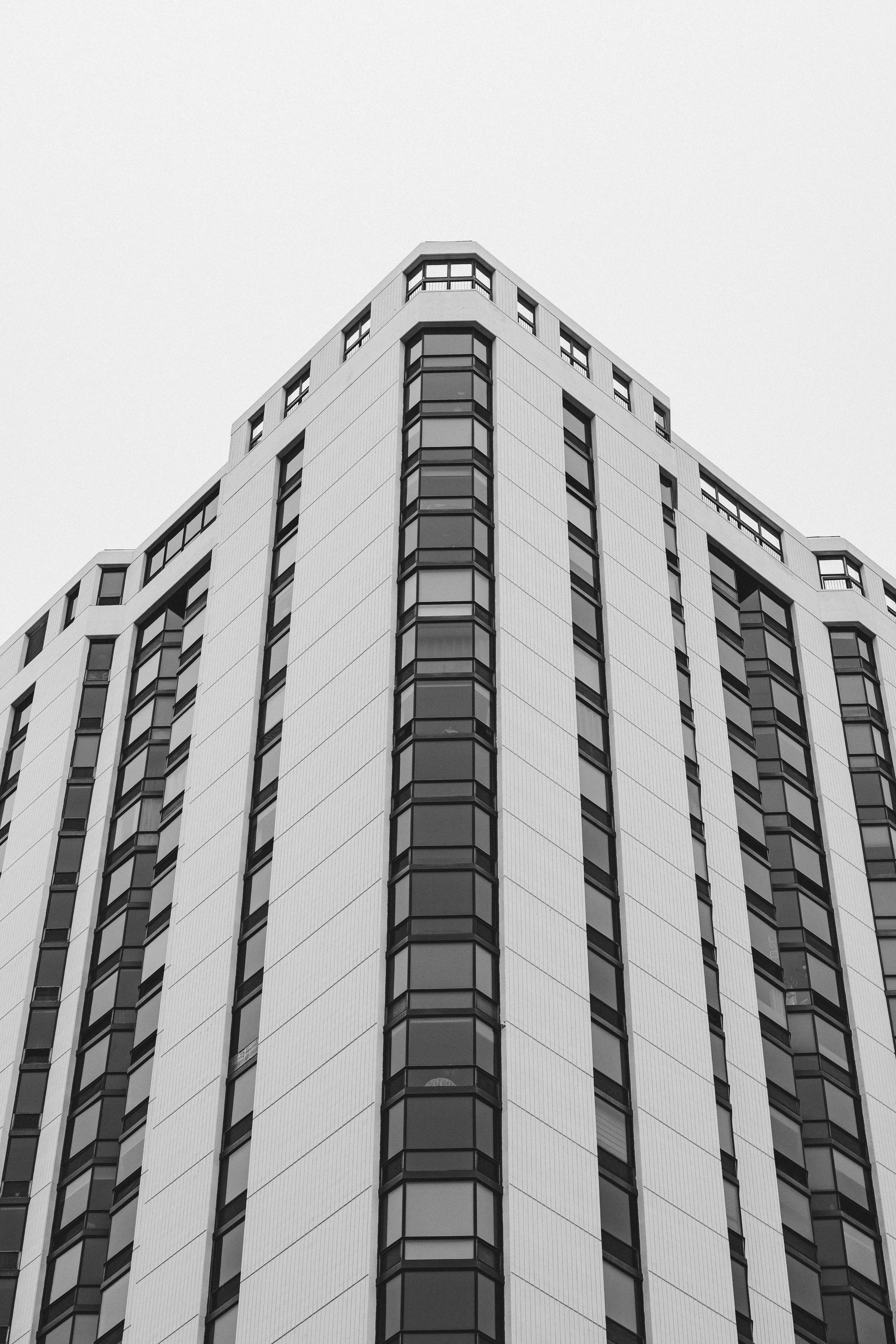 High-rise building with symmetrical windows and sharp lines against an overcast sky.