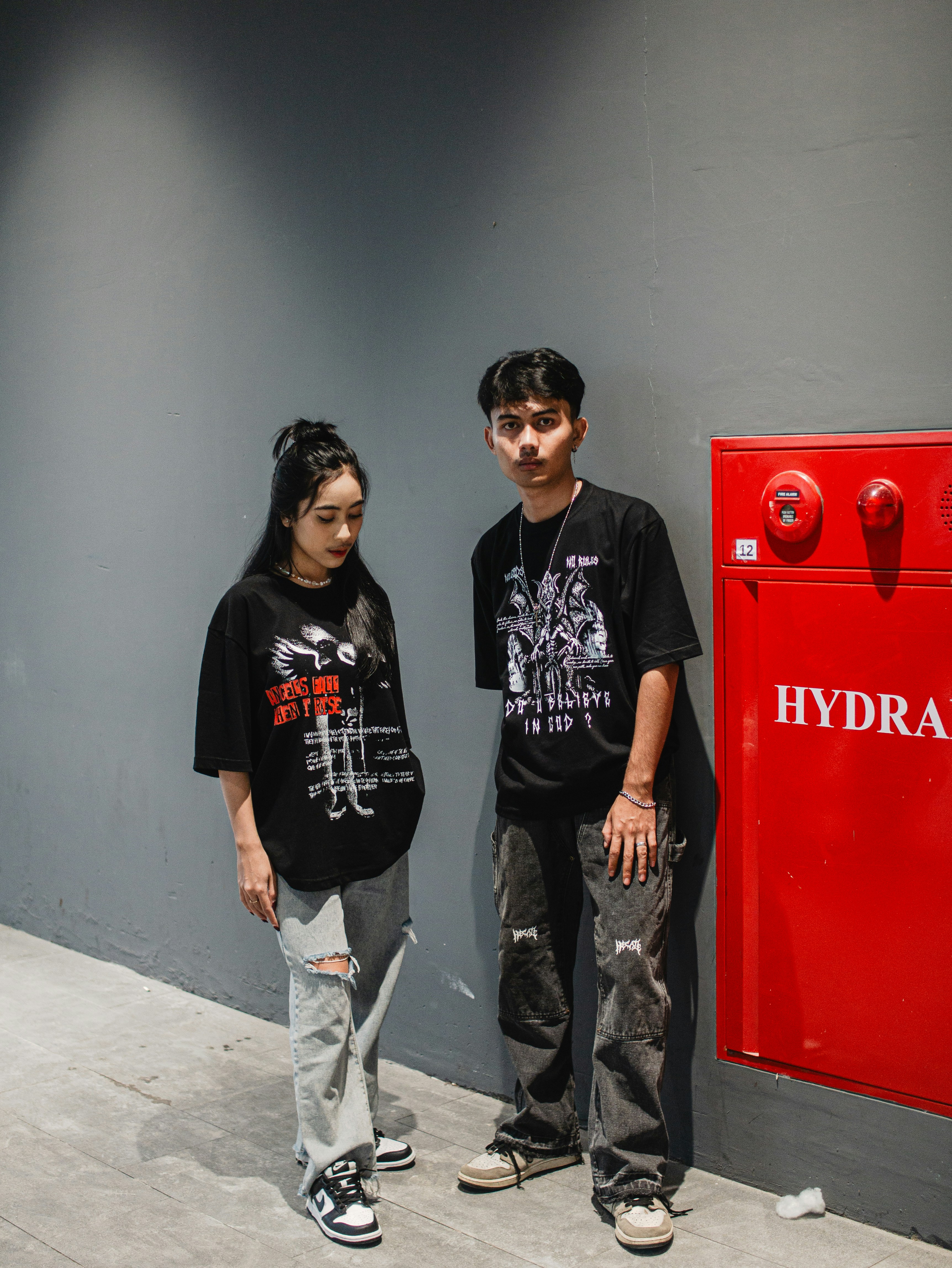 A couple of people standing next to a red fire hydrant photo – Free ...