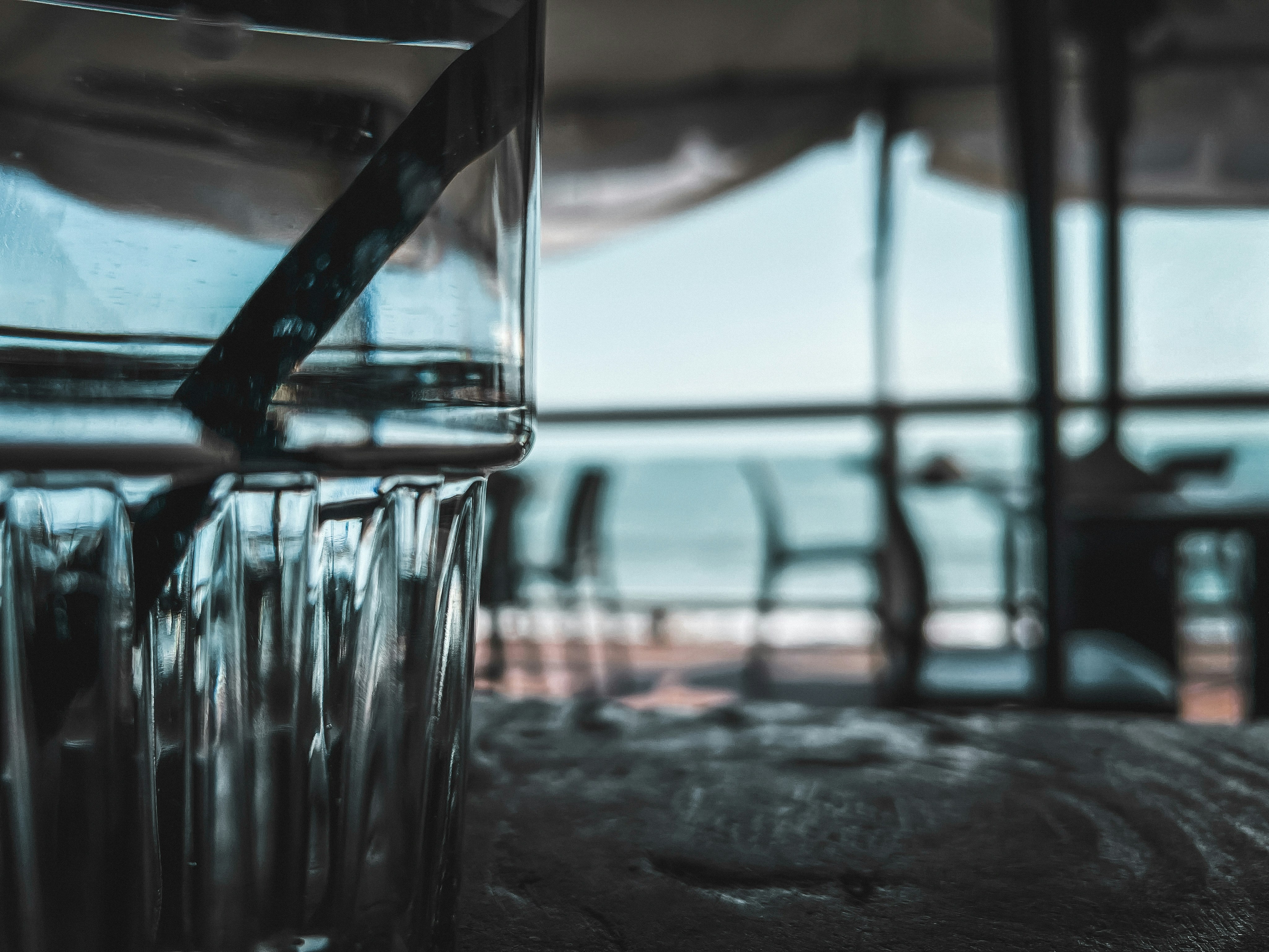 Row of Glass Tumblers Framing a Sea-View Café
