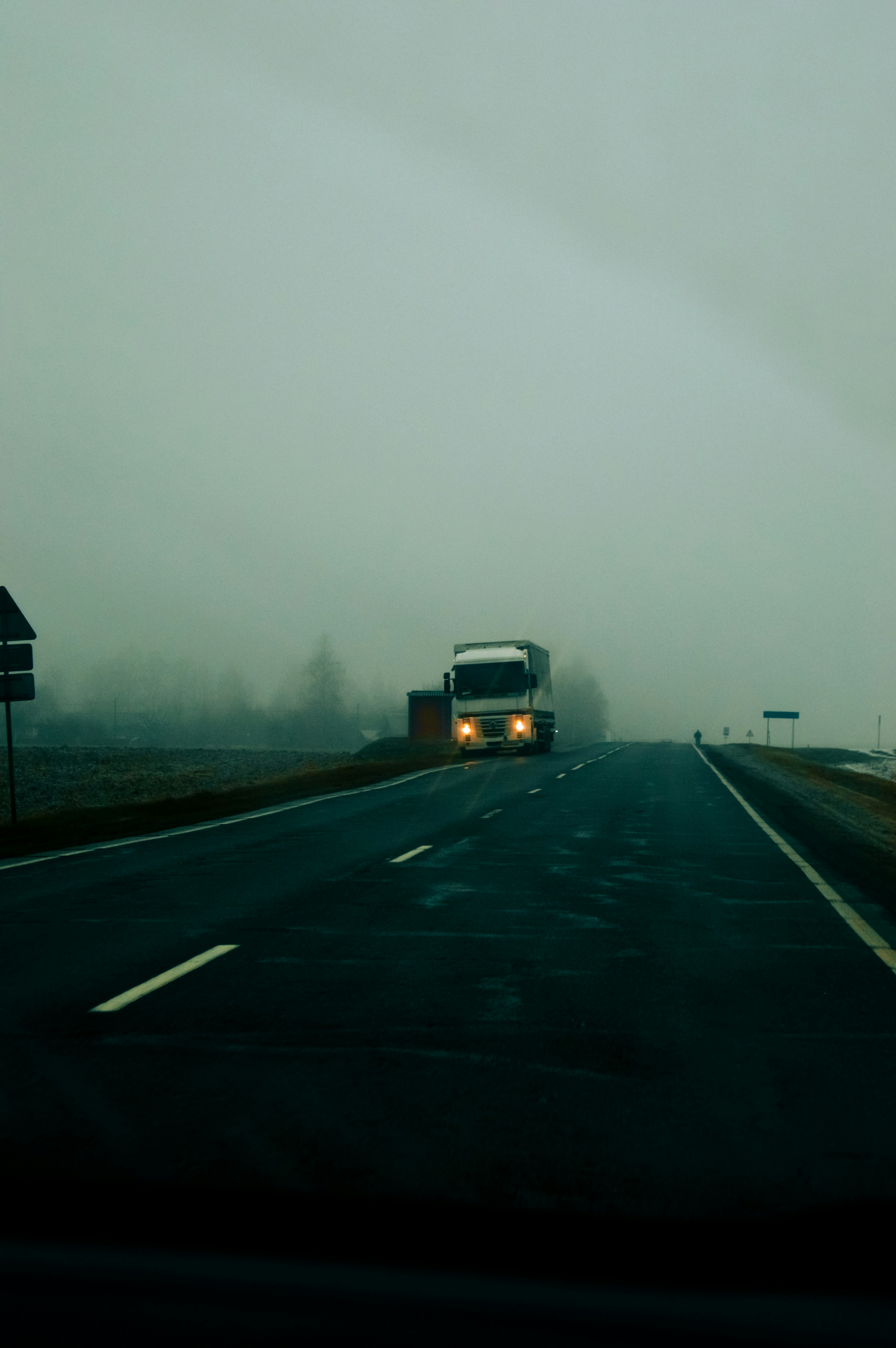 A bus driving down a road in the fog photo – Free Road trip Image on ...