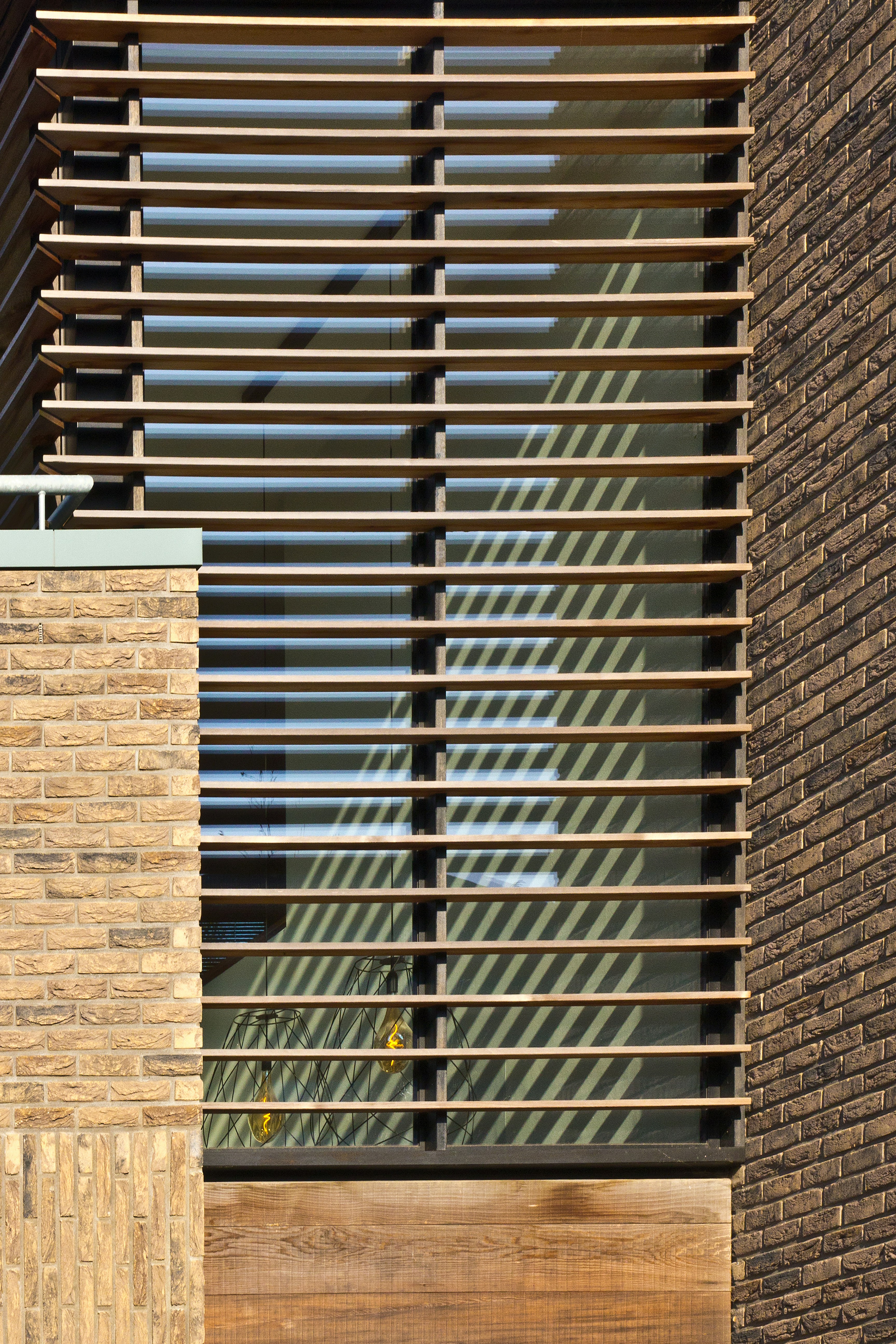 Lattice of Light Across Brick: Horizontal Slats Framing a Glass Facade