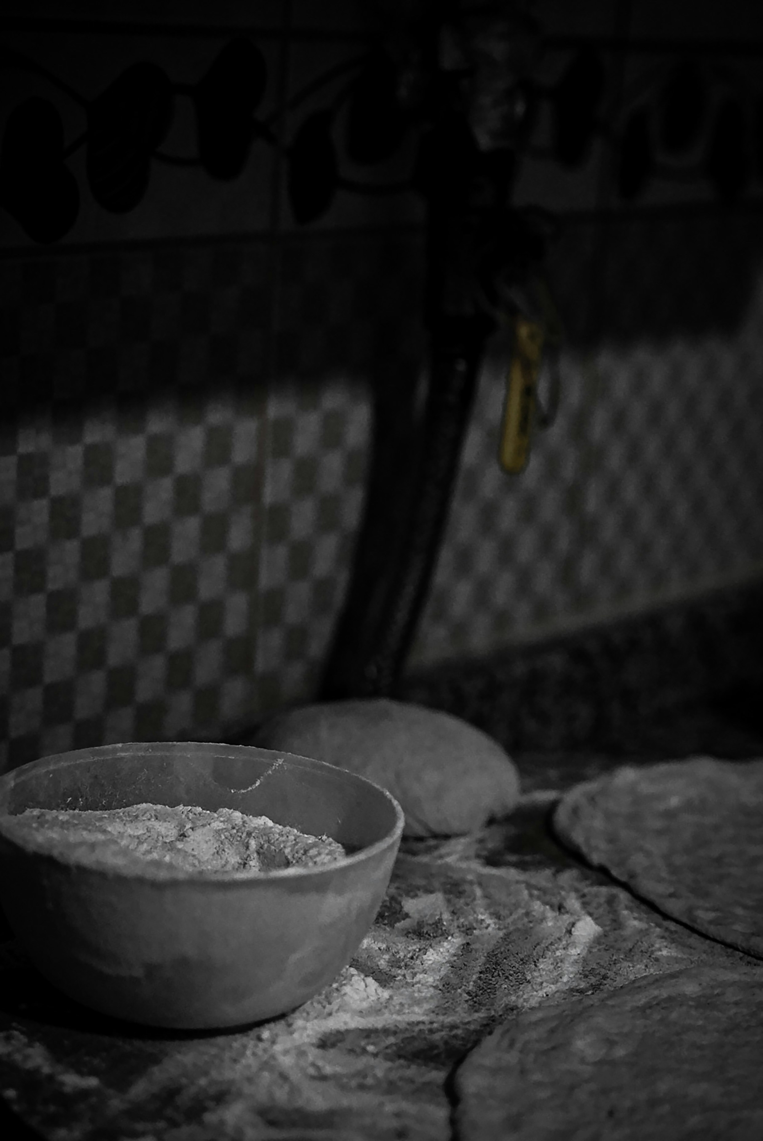 Dim Bakery Still Life: flour-dusted bowl under a shadowed kitchen