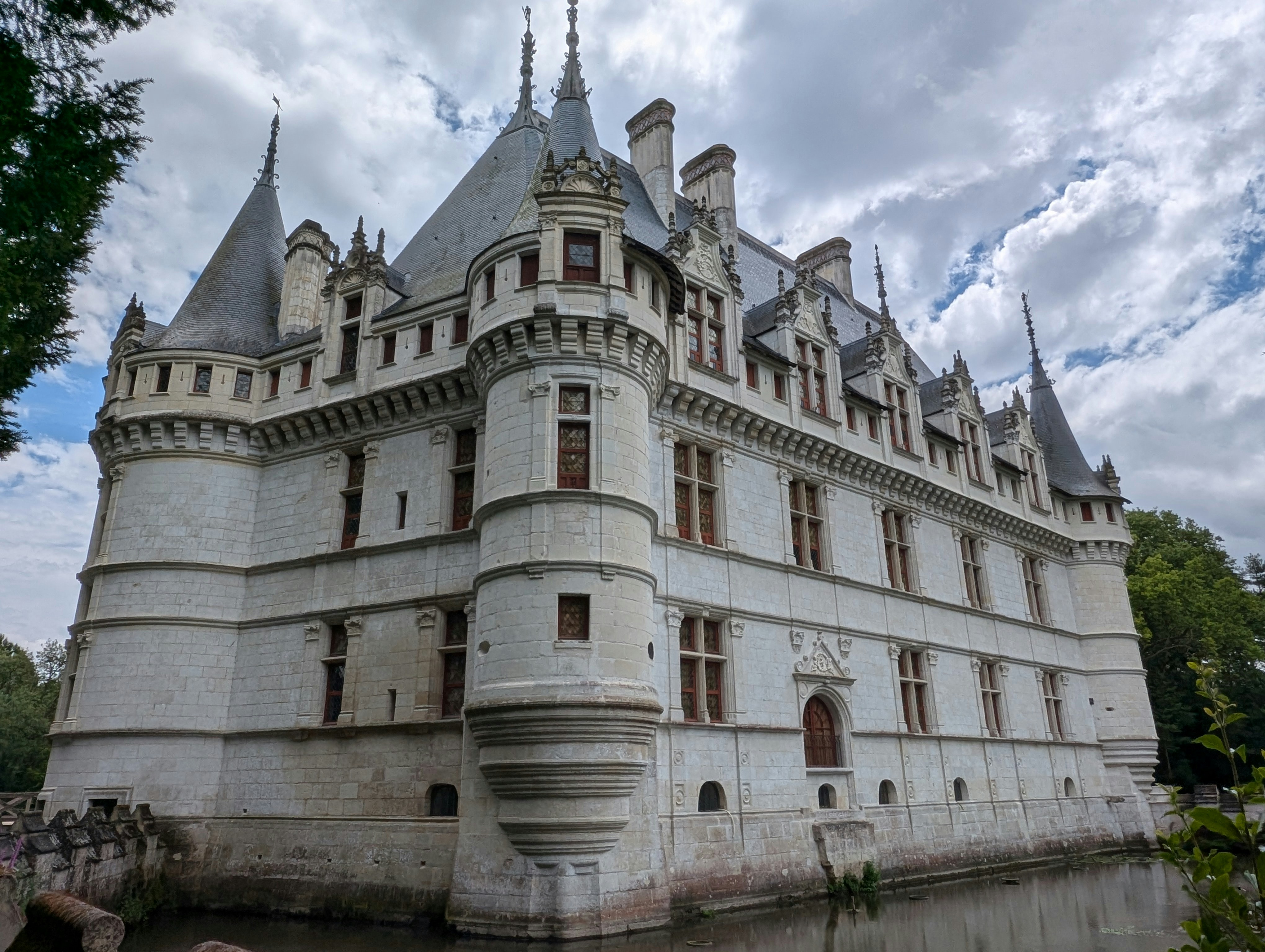 A large white castle sitting next to a body of water photo – Free Loire ...