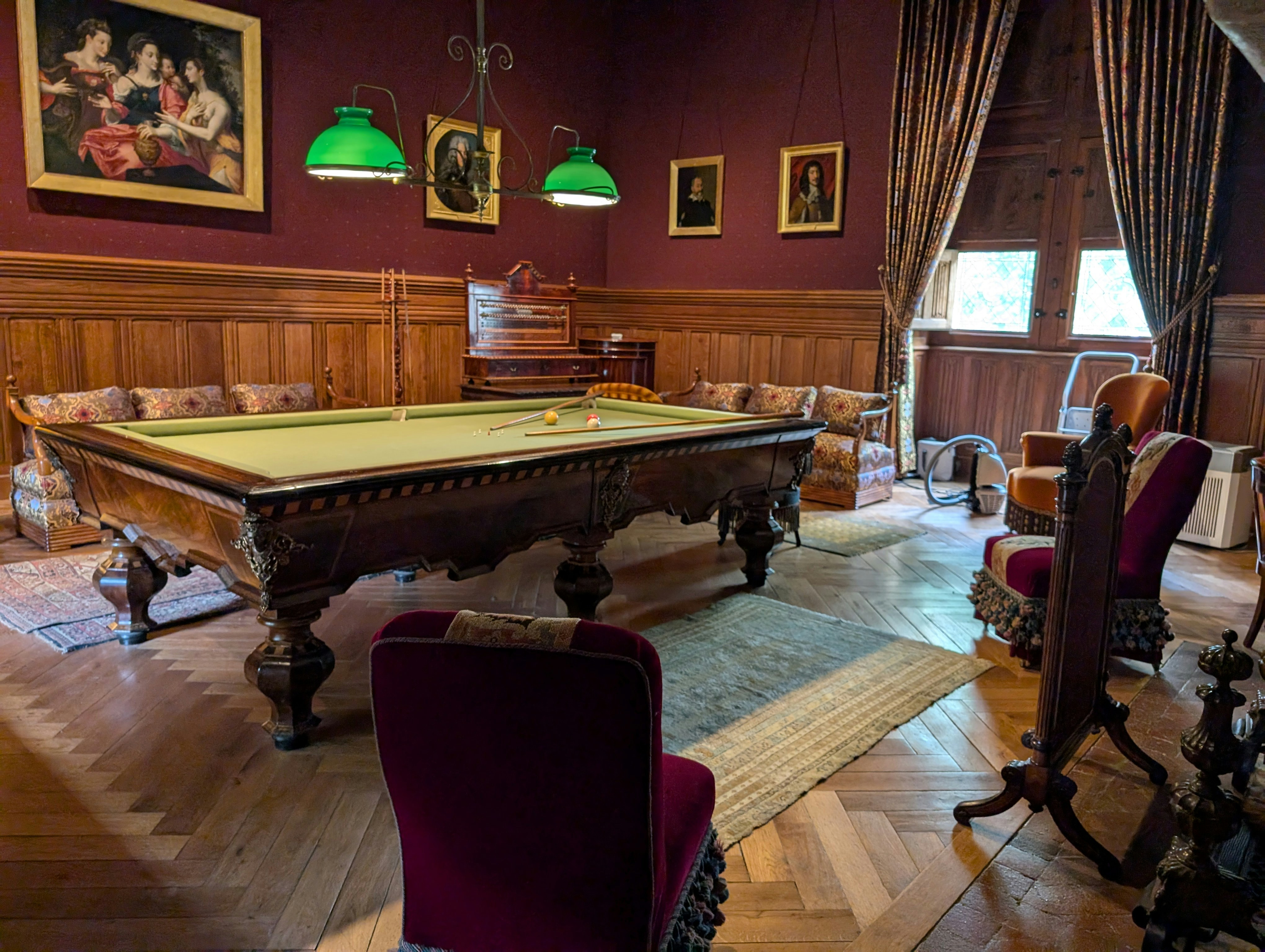 A room with a pool table, chairs and pictures on the wall photo – Free ...