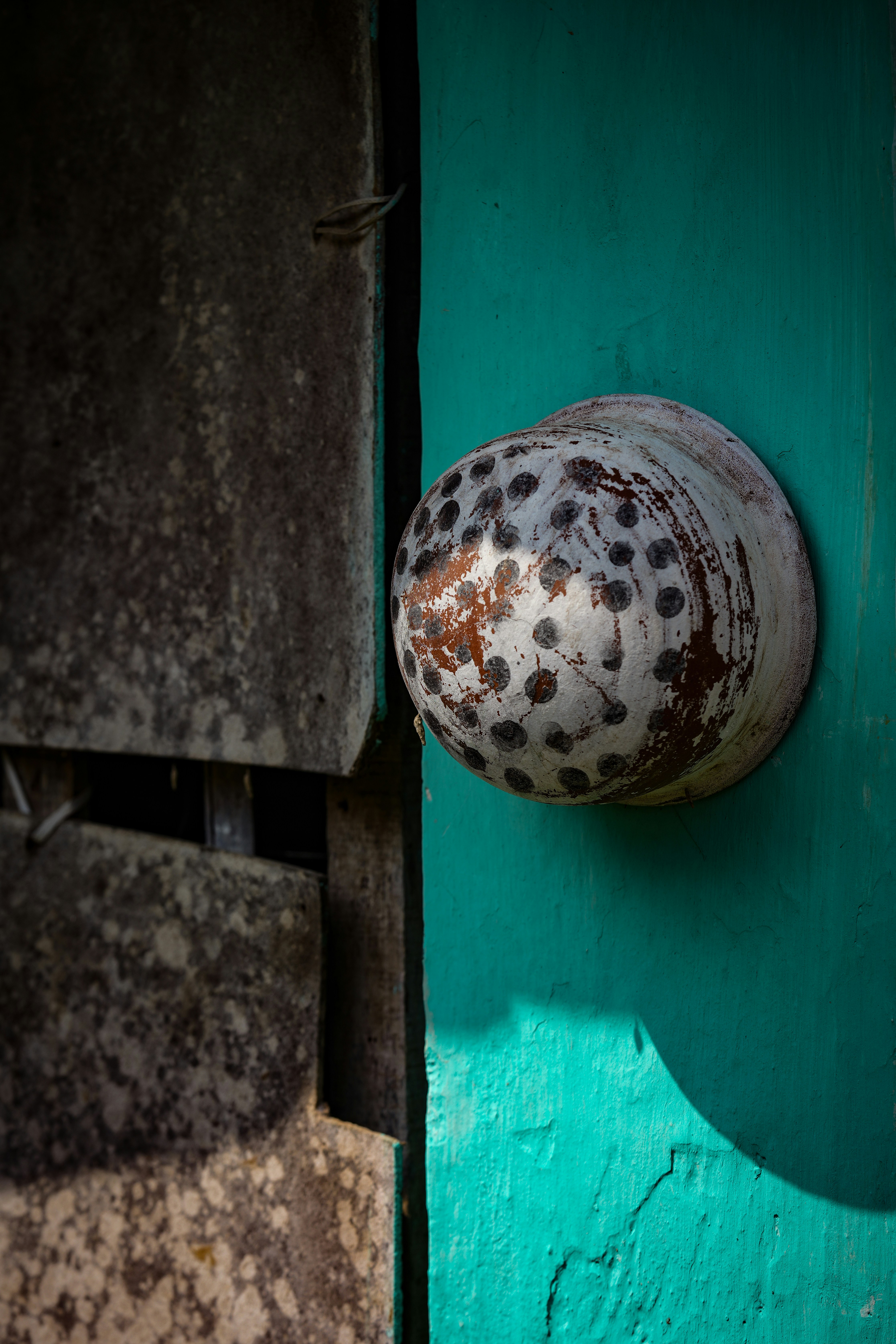 Patina on a Teal Threshold: Close-Up of a Rusted Doorknob