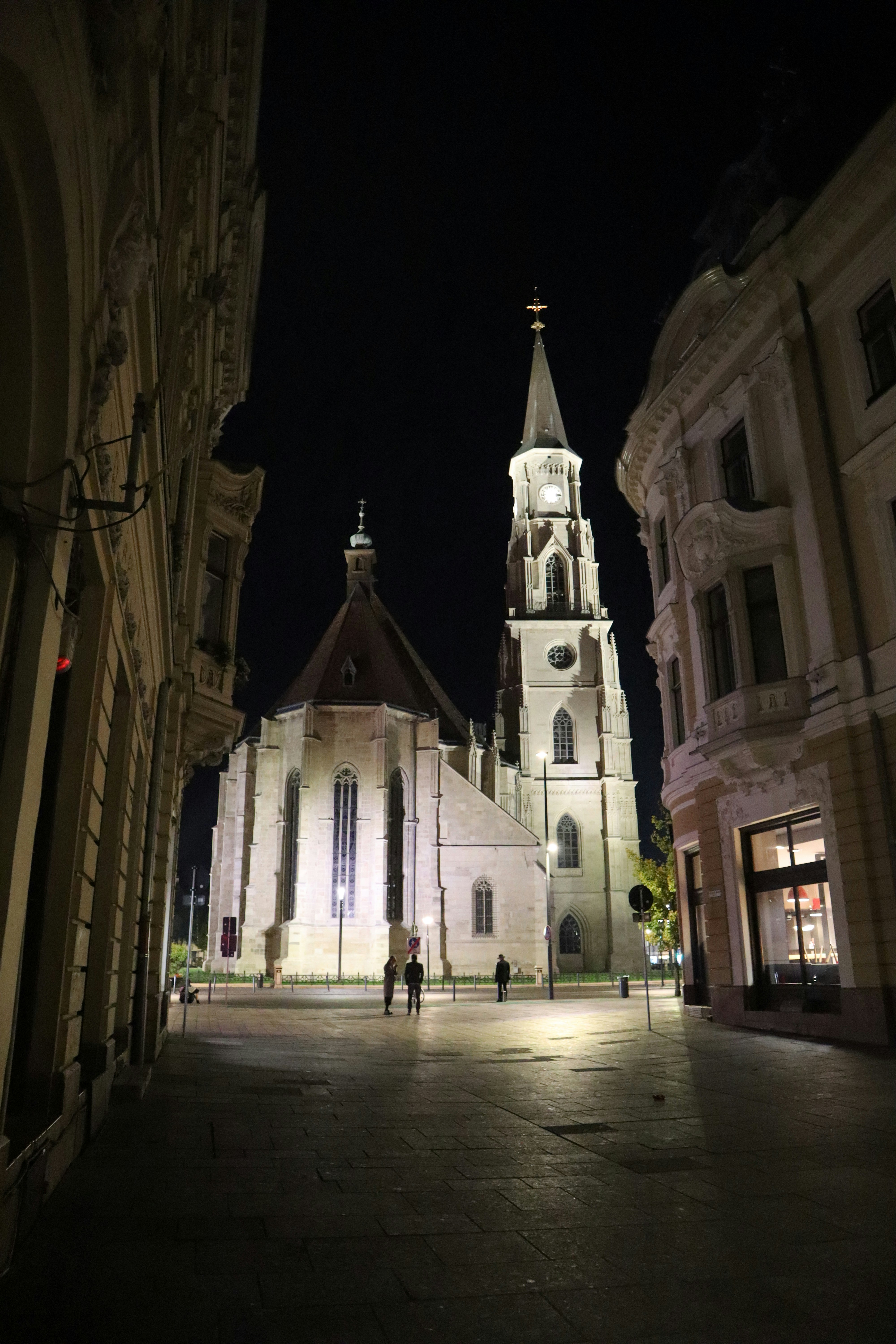 A church lit up at night with people walking around photo – Free ...