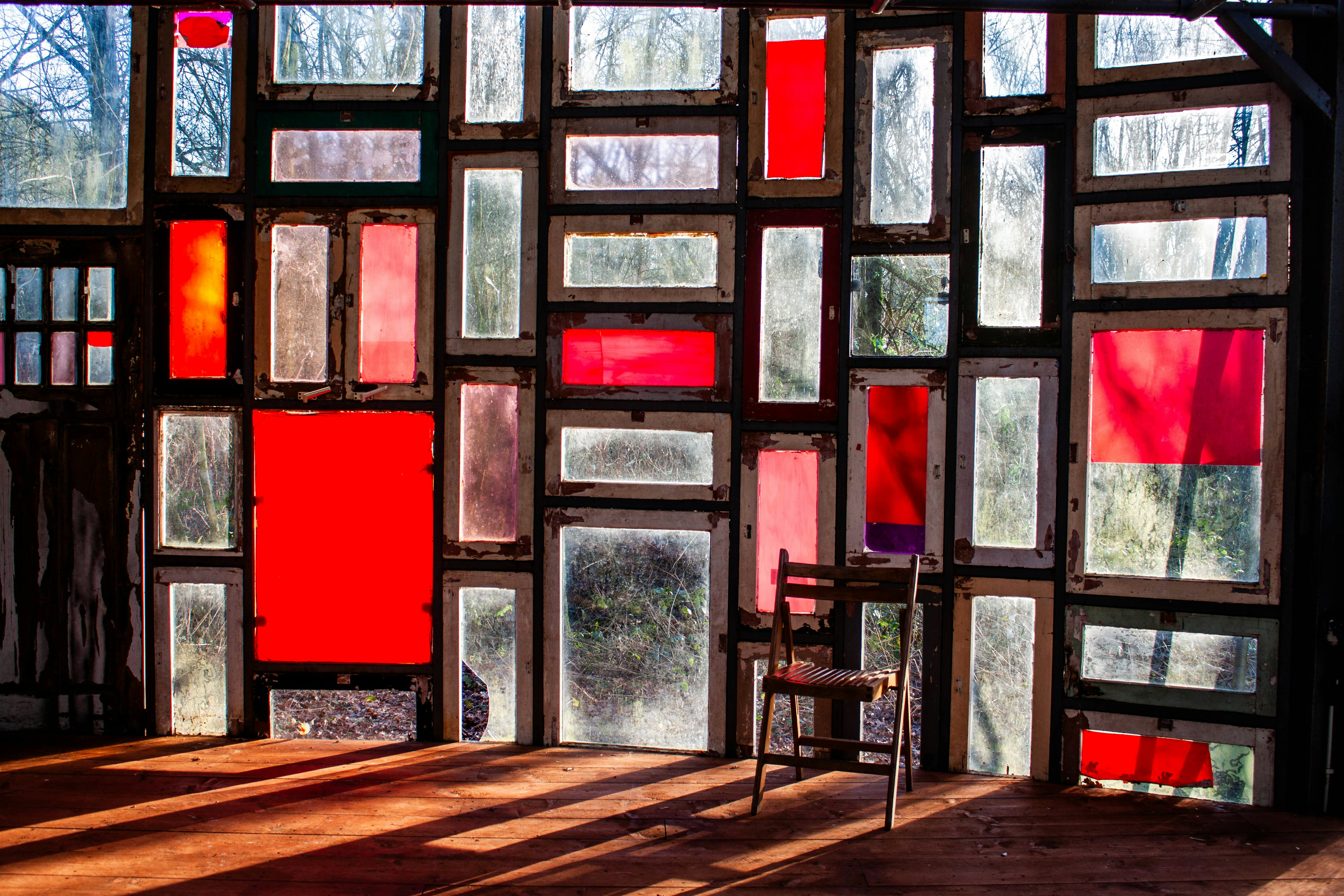 Sunlight streaming through a mosaic of colorful window panes, casting vibrant patterns on a wooden floor.