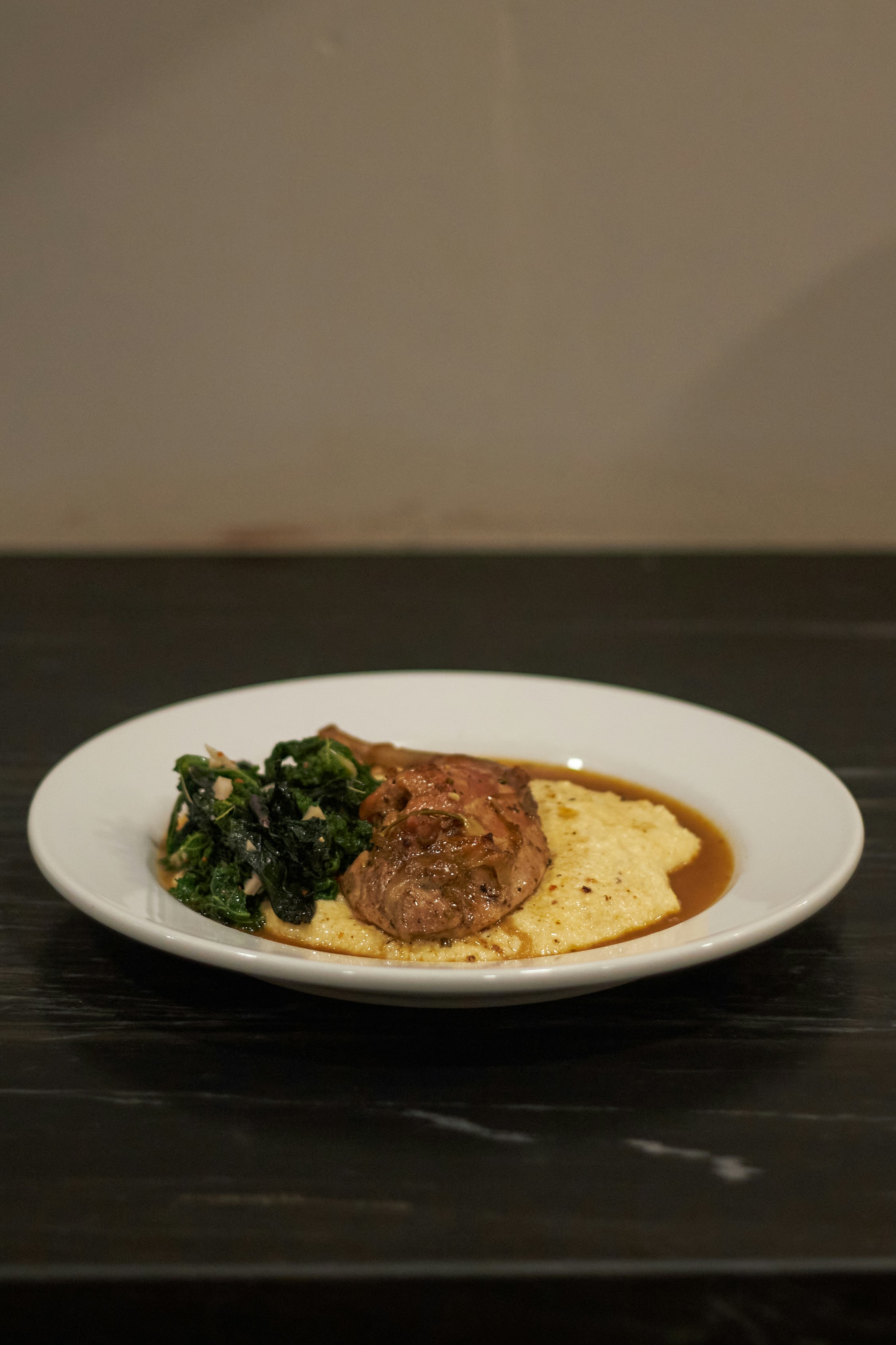 Beef Tenderness on Polenta with Wilted Greens in Warm Indoor Light