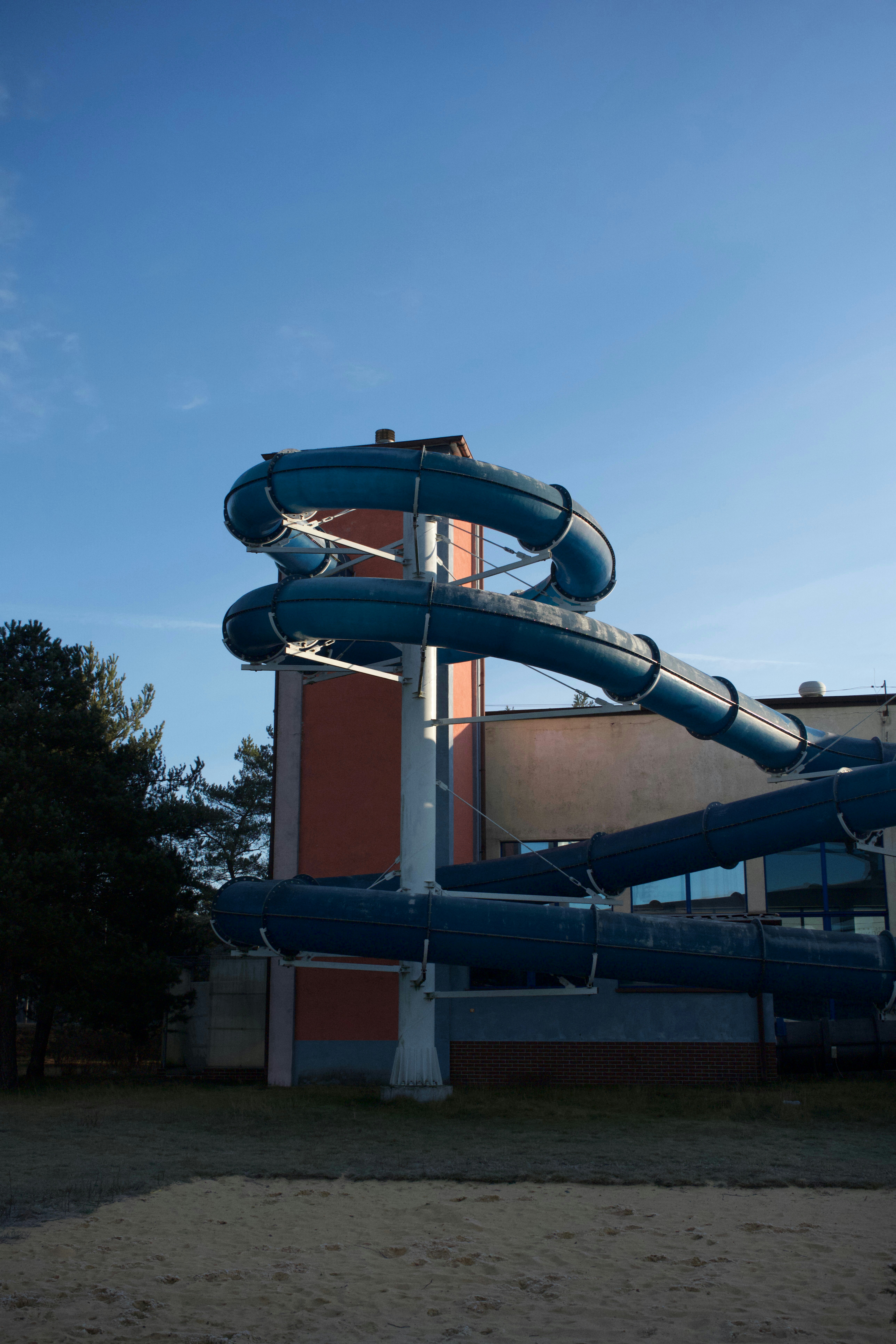 Blue Helix Over a Brick Tower: A Quiet Twist of a Water Slide