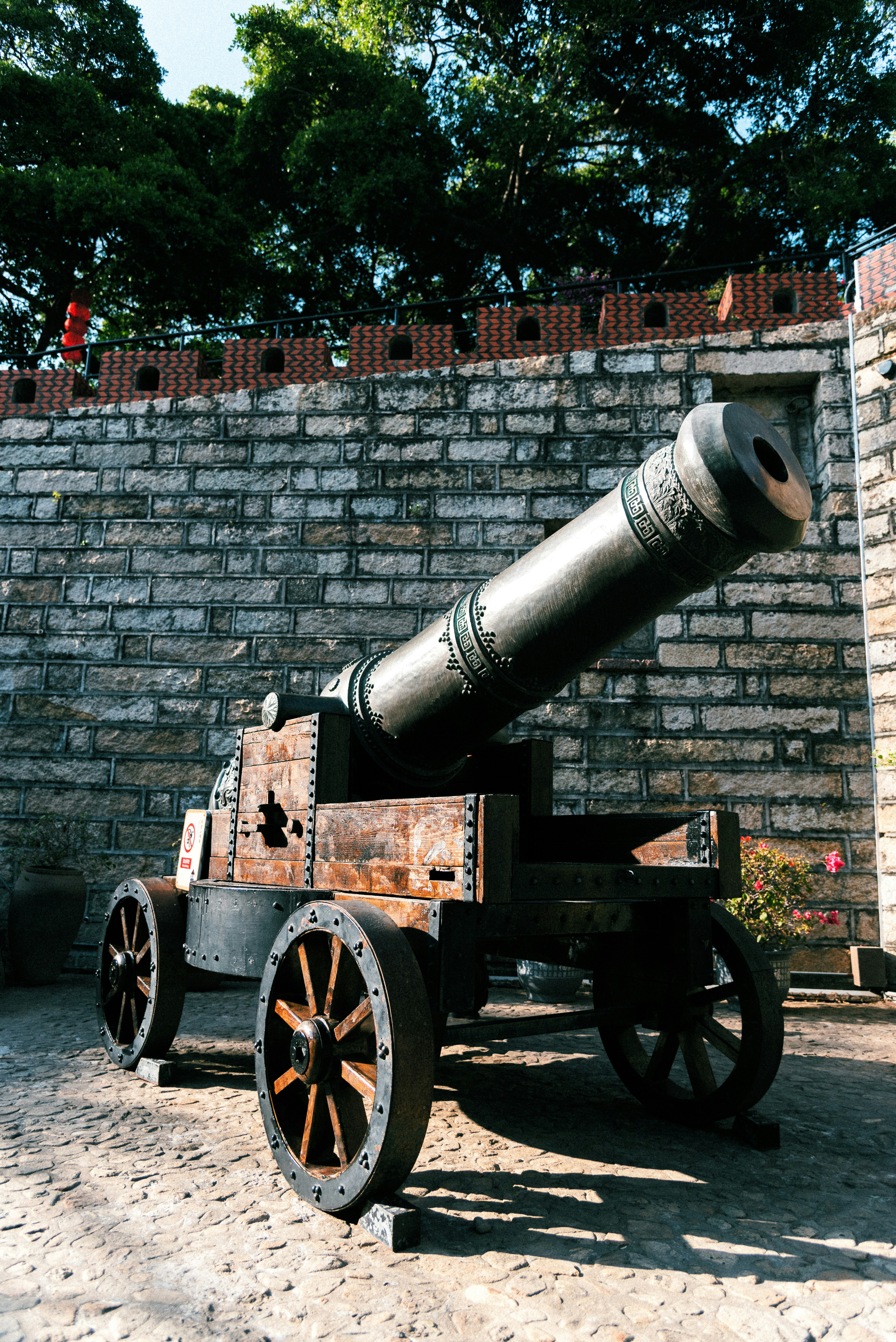 An old cannon sitting in front of a brick wall photo – Free Weapon ...