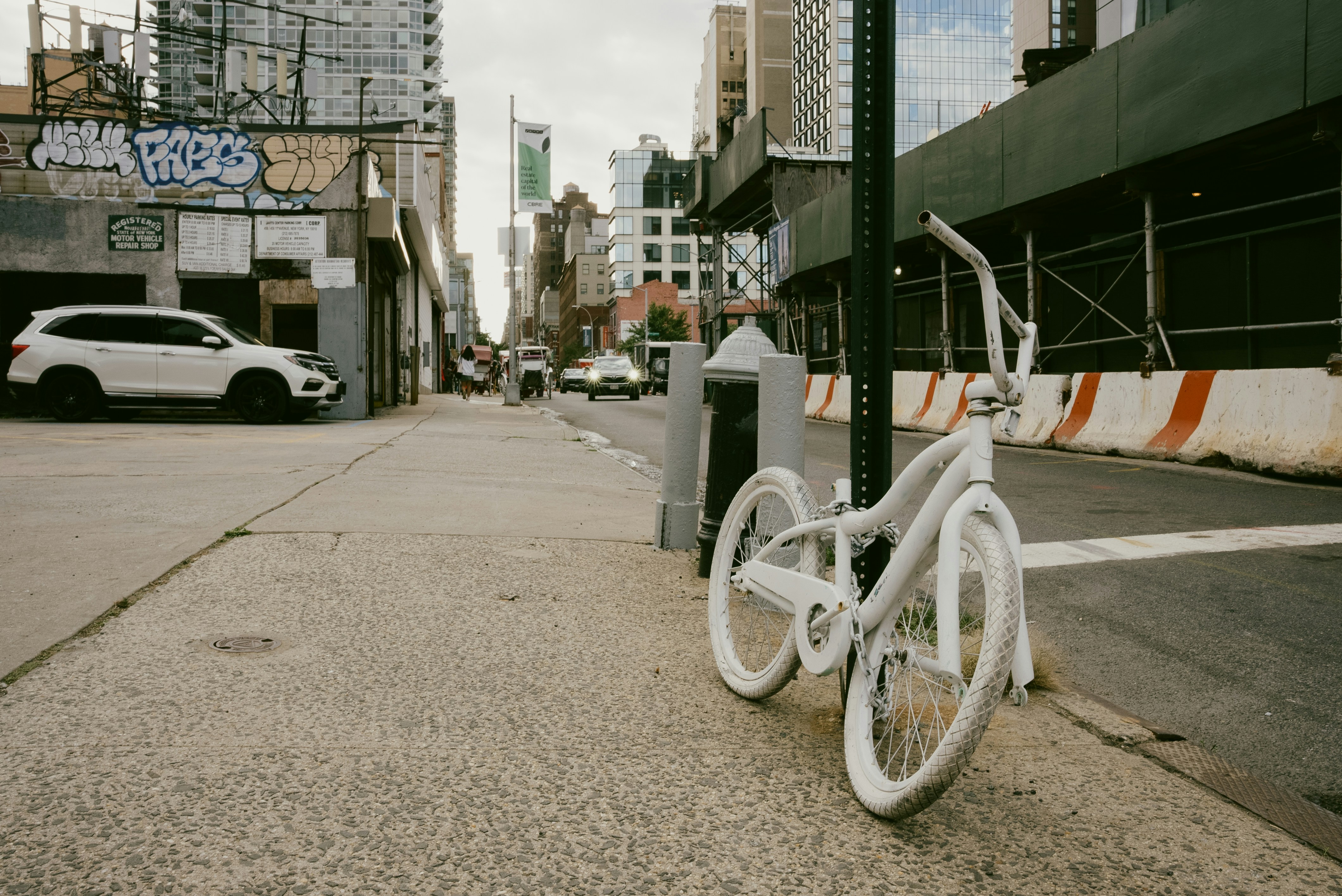 A white bicycle parked on the side of a road