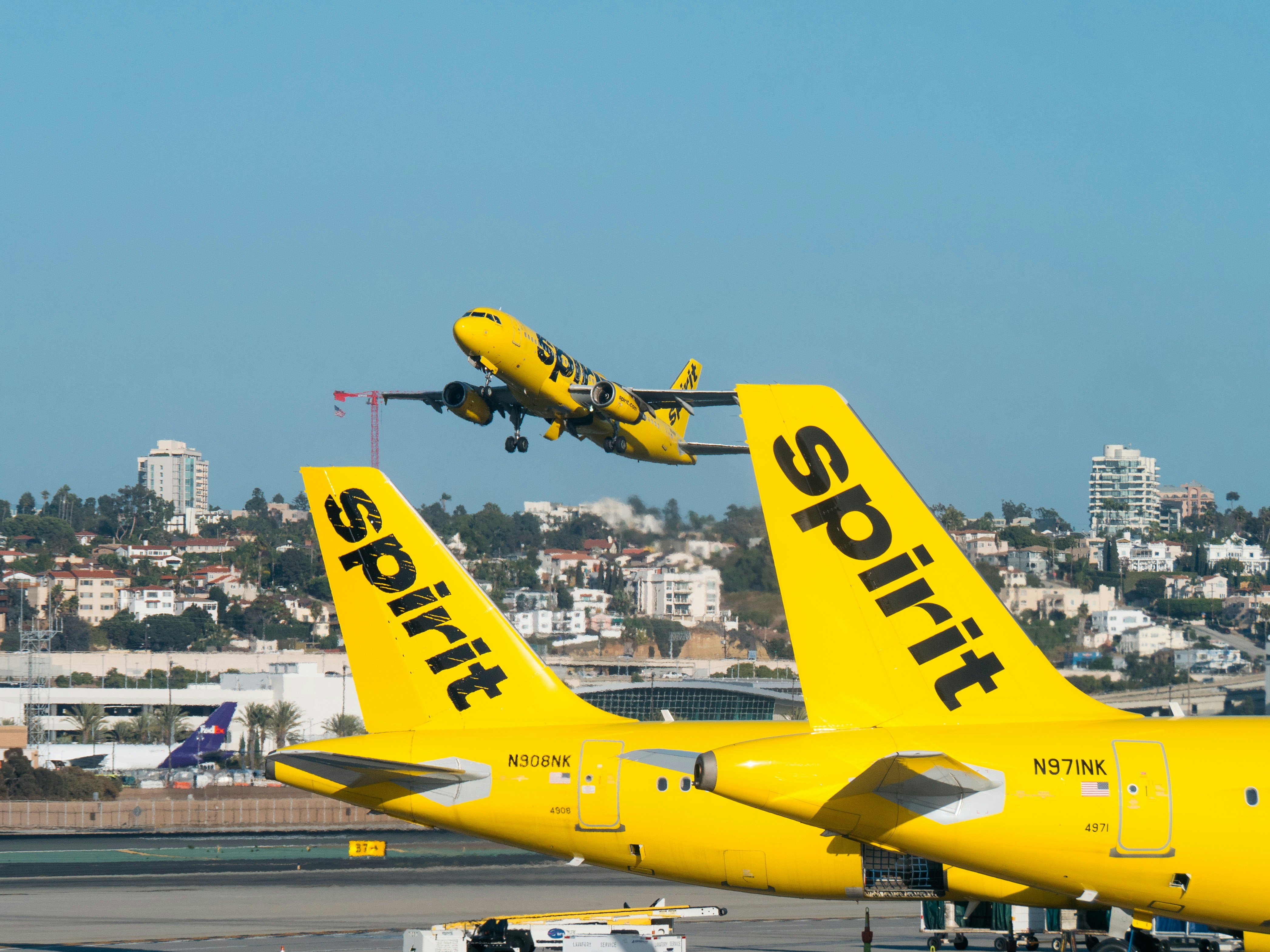 Sunlit Spirit: A Yellow Jet Lift-off Over a Coastal Airport