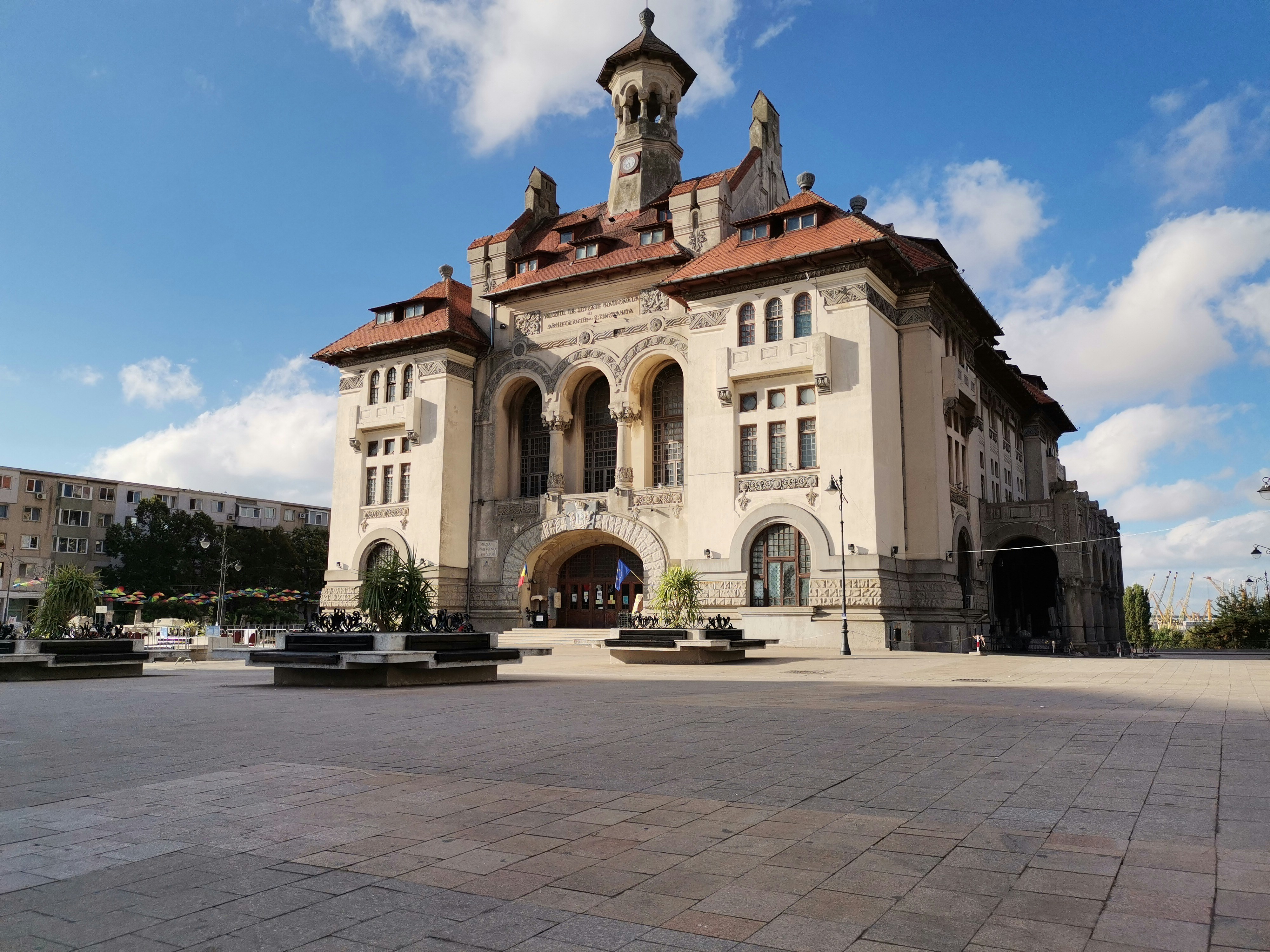 Historic building of the National Museum of History and Archaeology in Constanța under a vibrant blue sky.