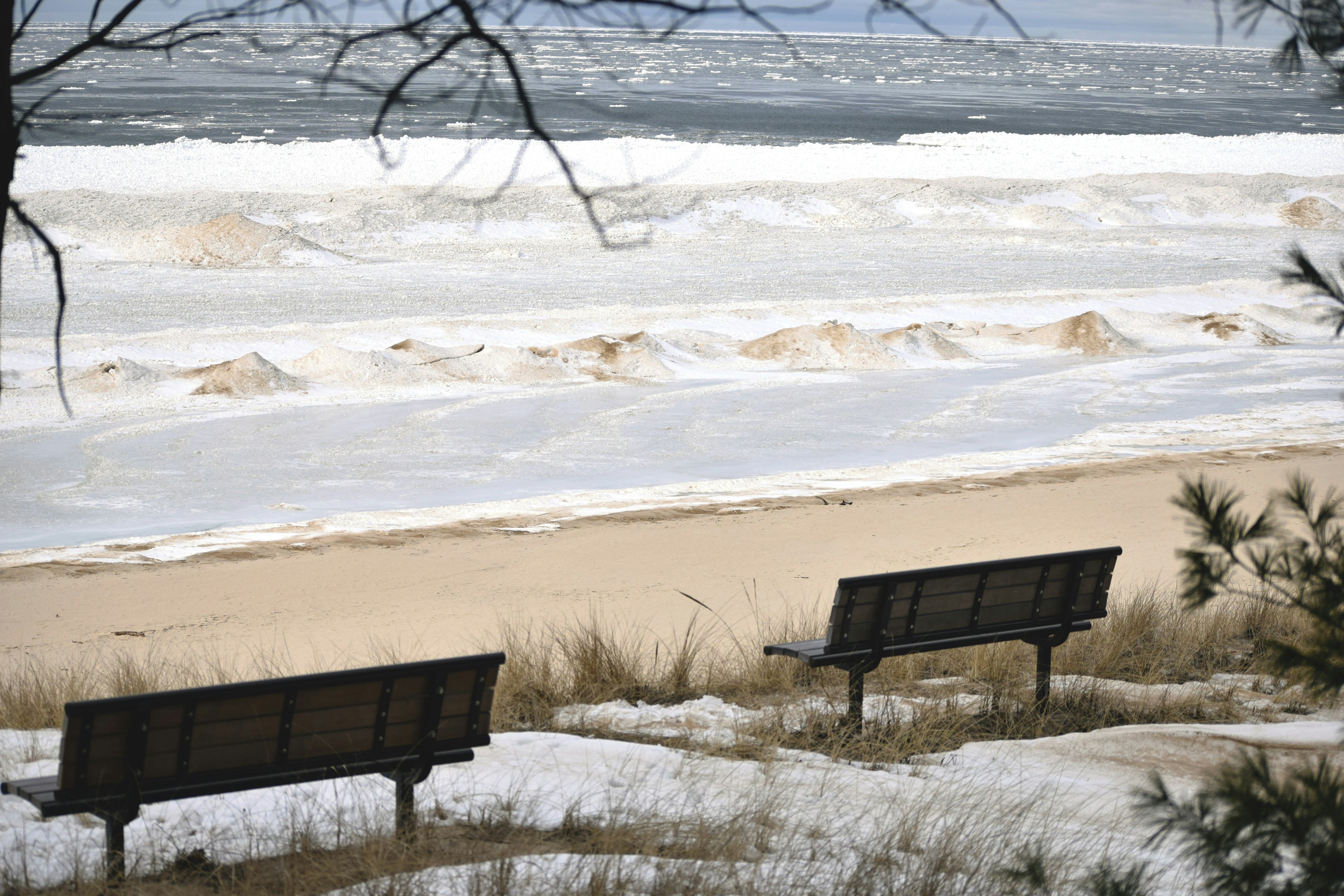 Snow-Kissed Shoreline: Paired Benches Over Quiet Ice