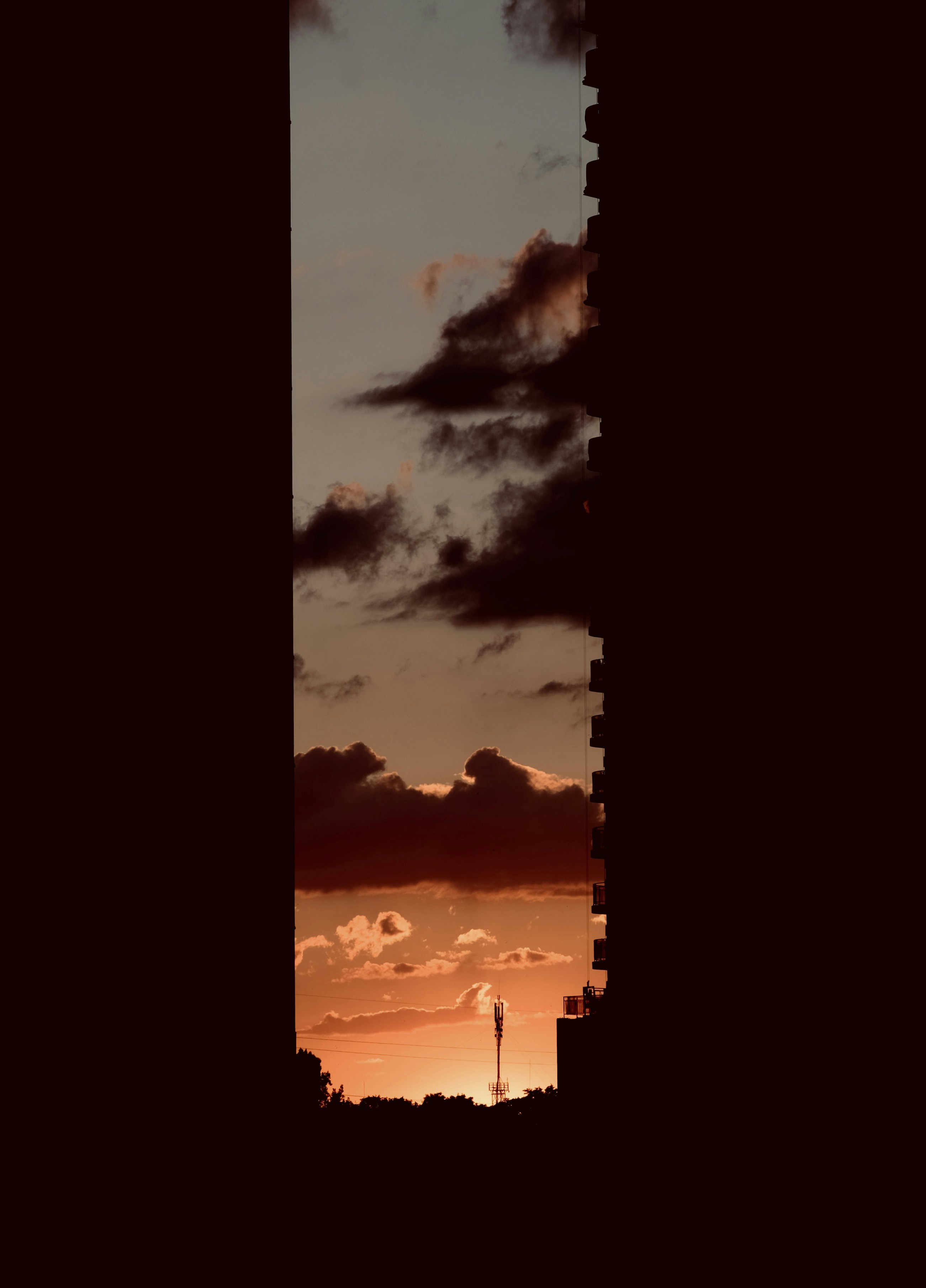 Horizon Framed by Dark Slits: Sunset Between Two Facades