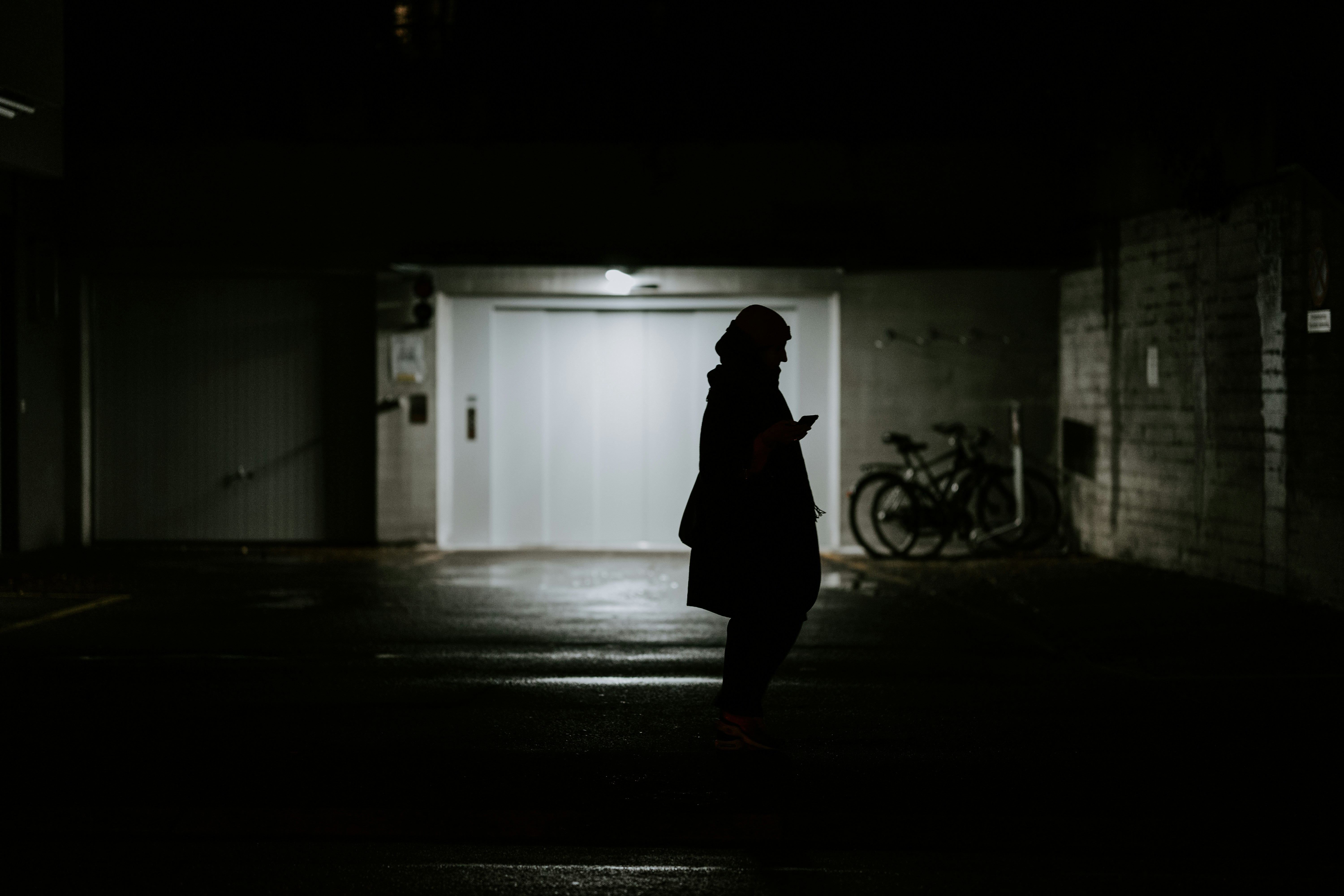 A person standing in a dark alley at night photo – Free Woman Image on ...