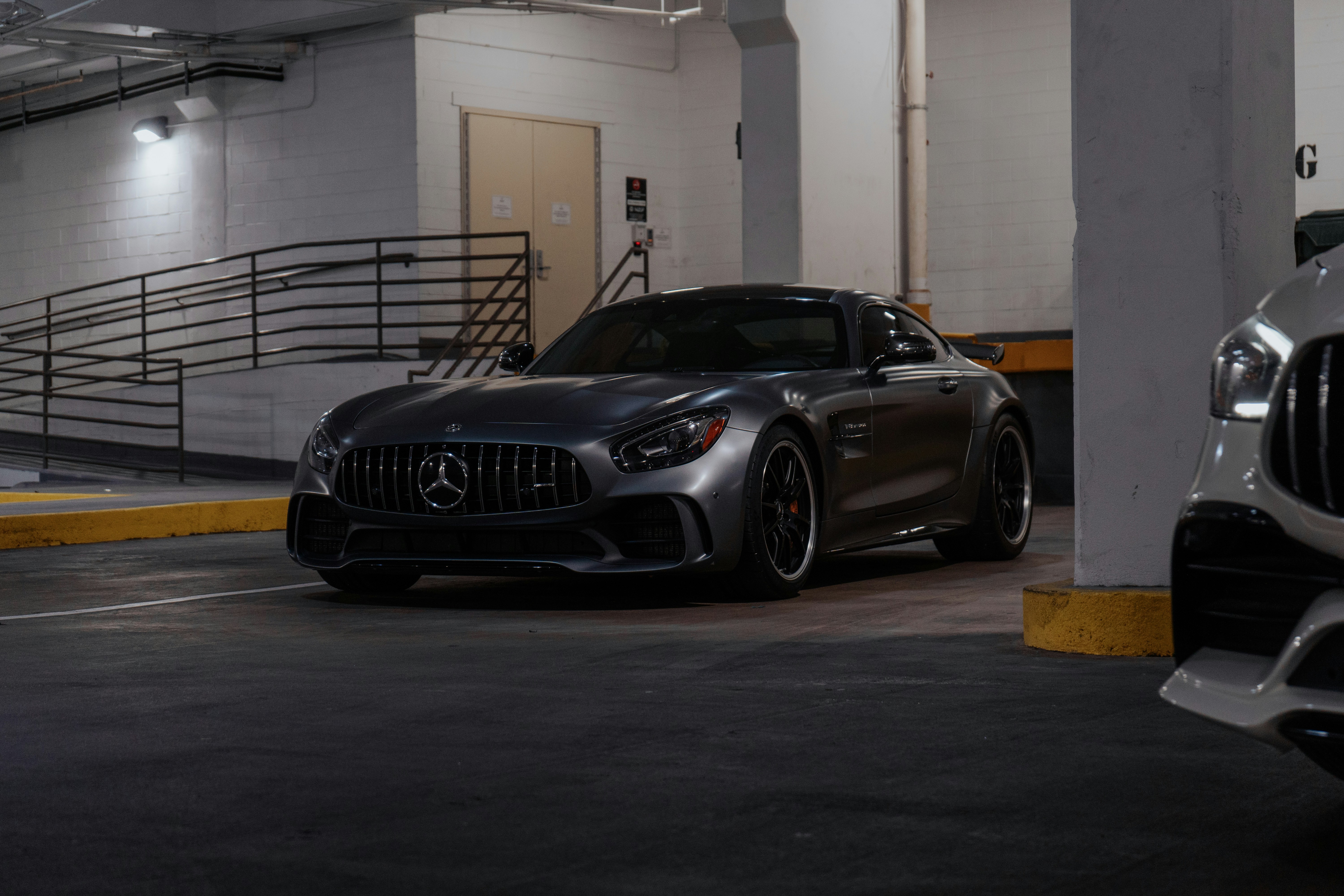 Two cars parked in a parking garage next to each other photo – Free Car ...