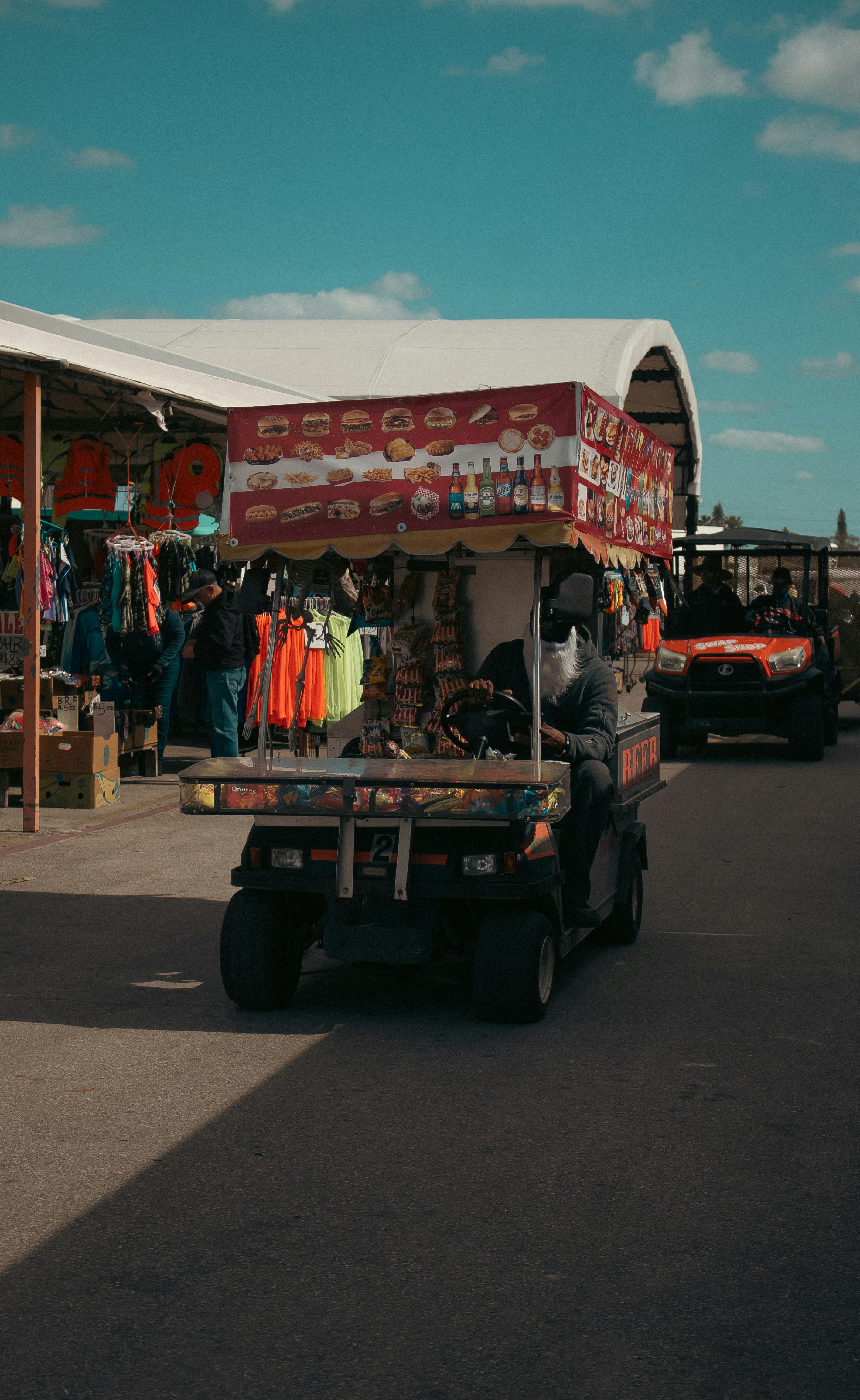 Food Cart with Colorful Snack Banner at a Market Row