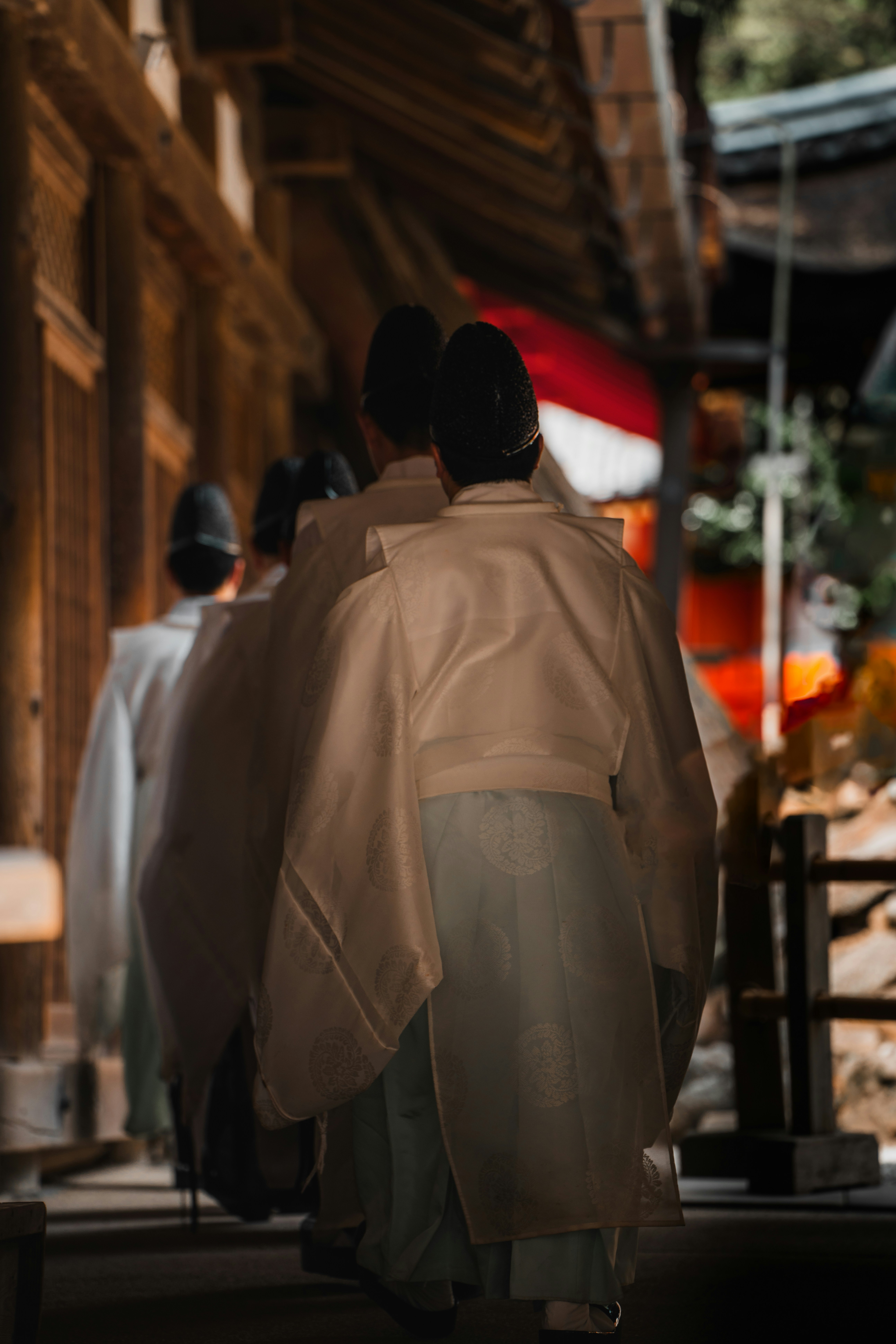 White-Robed Procession Through a Timber-Temple Corridor