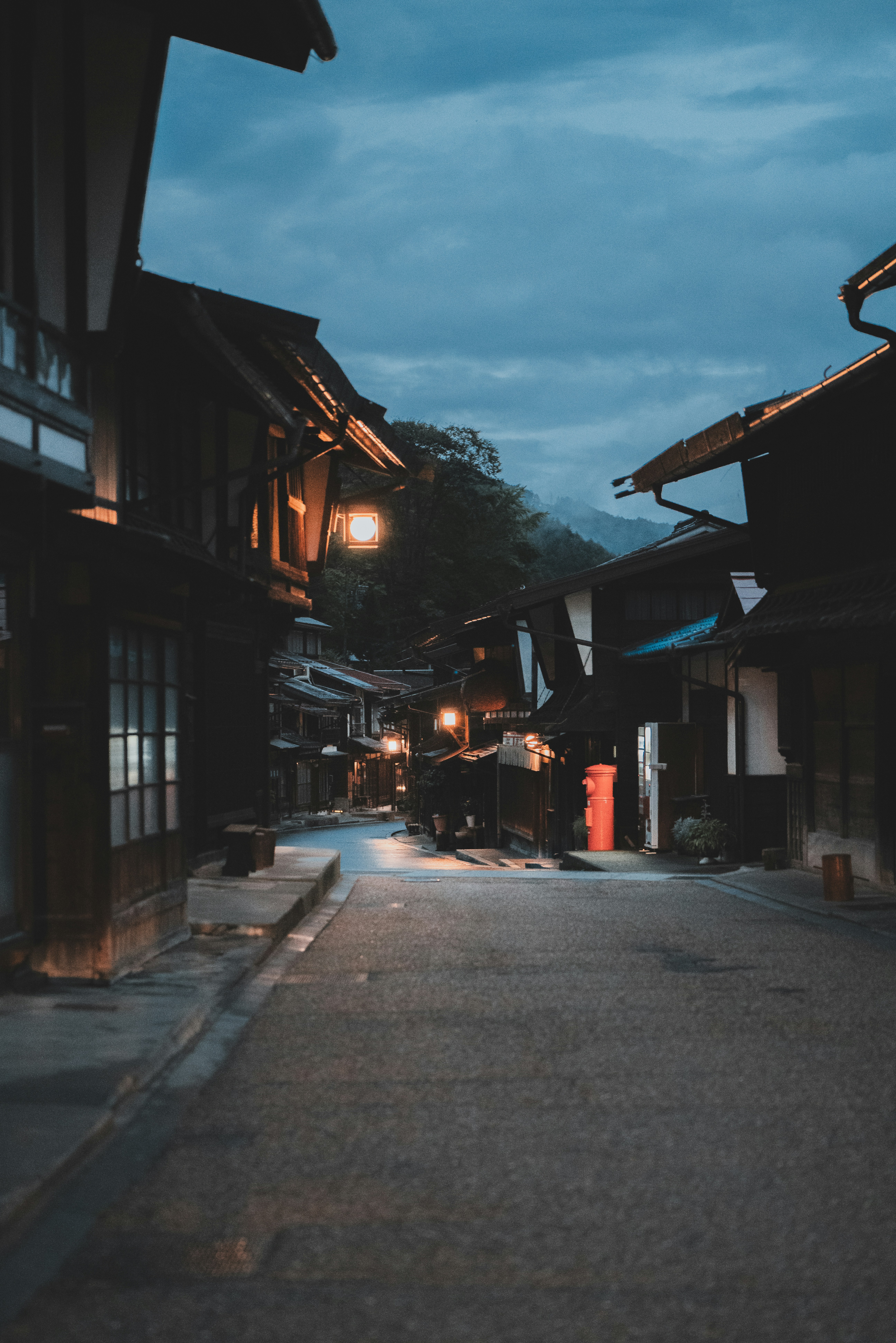 Amber Lanterns Guiding a Quiet Timber Street at Dusk