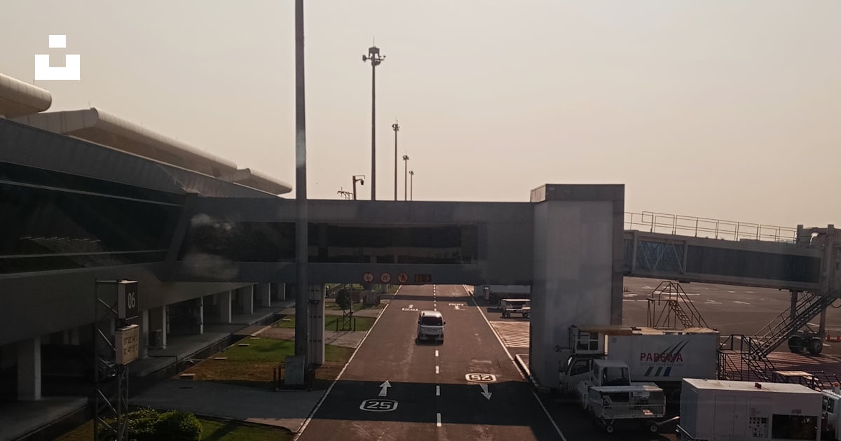 공항 활주로 옆에 자동차가 주차되어 있습니다 사진 Unsplash의 무료 길 이미지