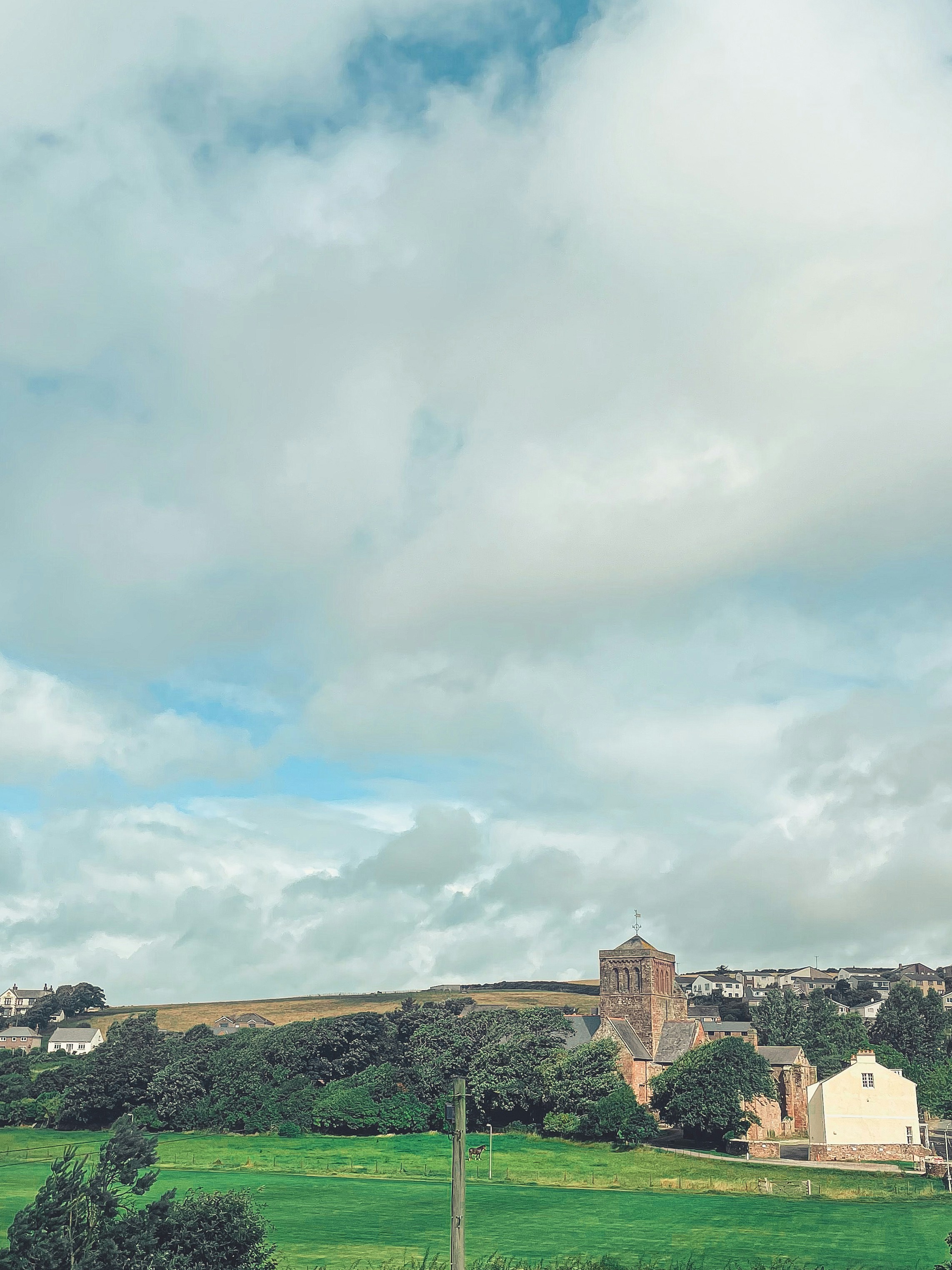 A green field with buildings in the background photo – Free St bees ...