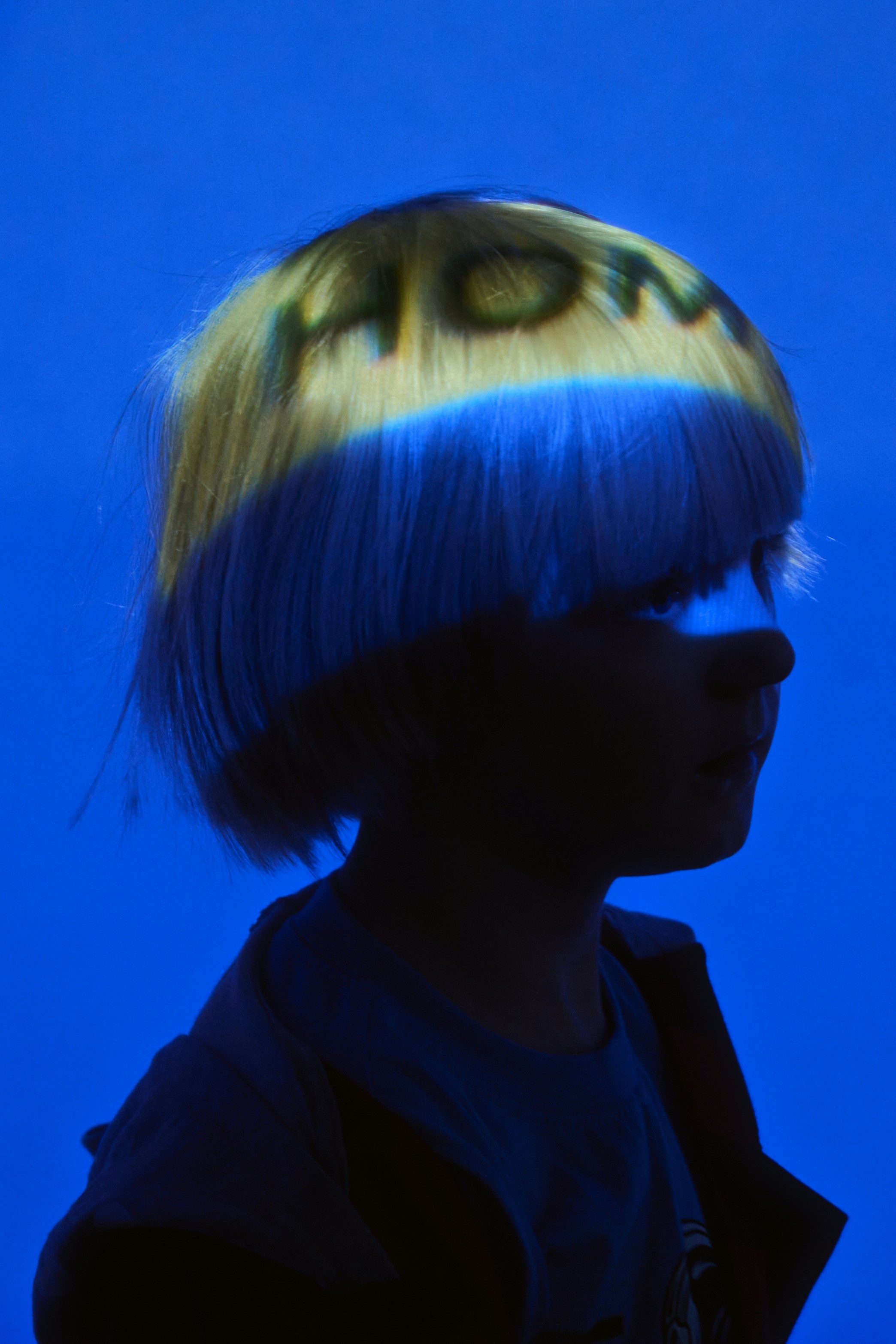 Cobalt Halo: Profile portrait with neon two-tone fringe and crown projection