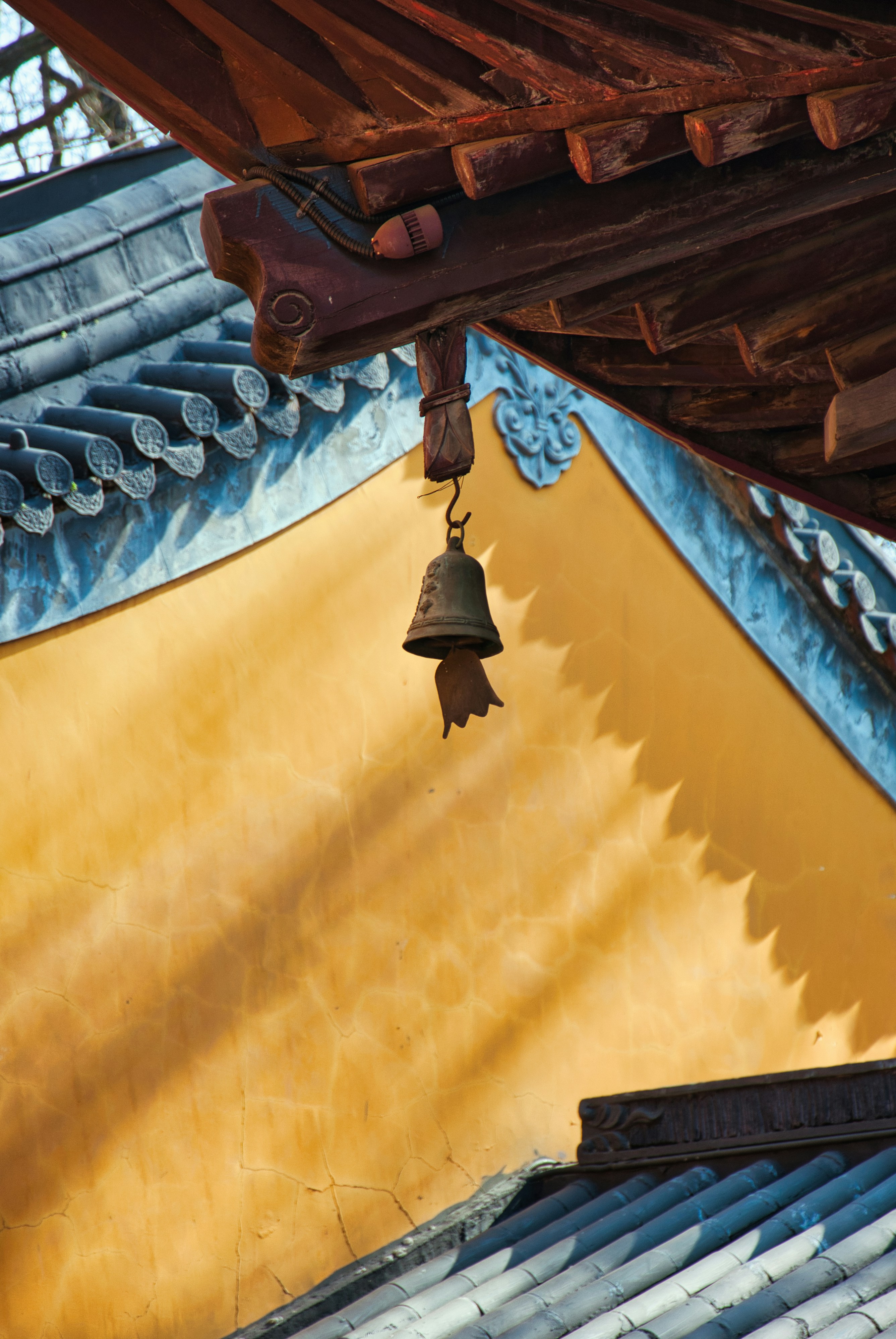 A bell hanging from the roof of a building photo – Free Bell Image on ...