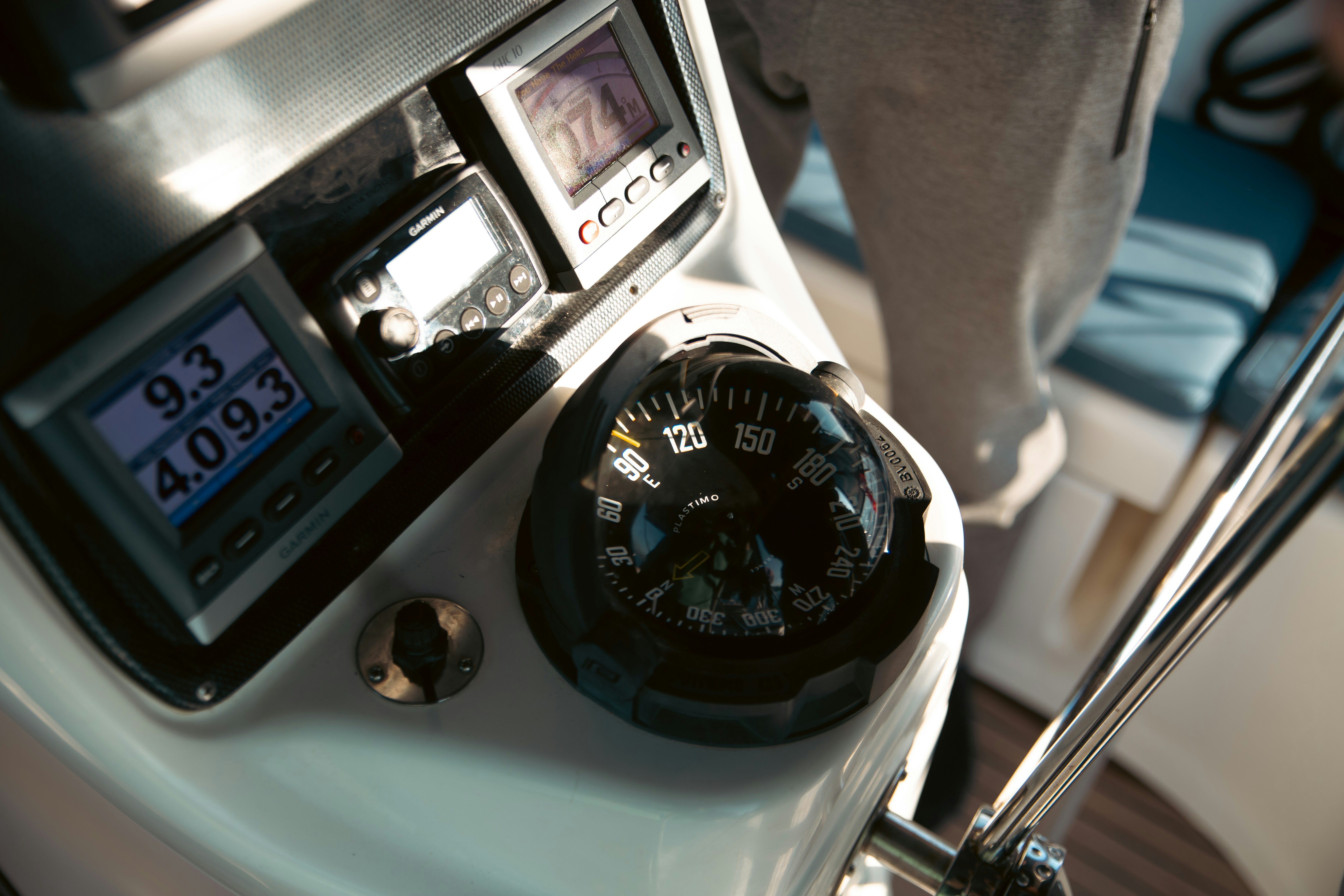 Close-up of a boat's control panel featuring a speedometer and digital displays. The setting emphasizes navigation and control in a marine environment.