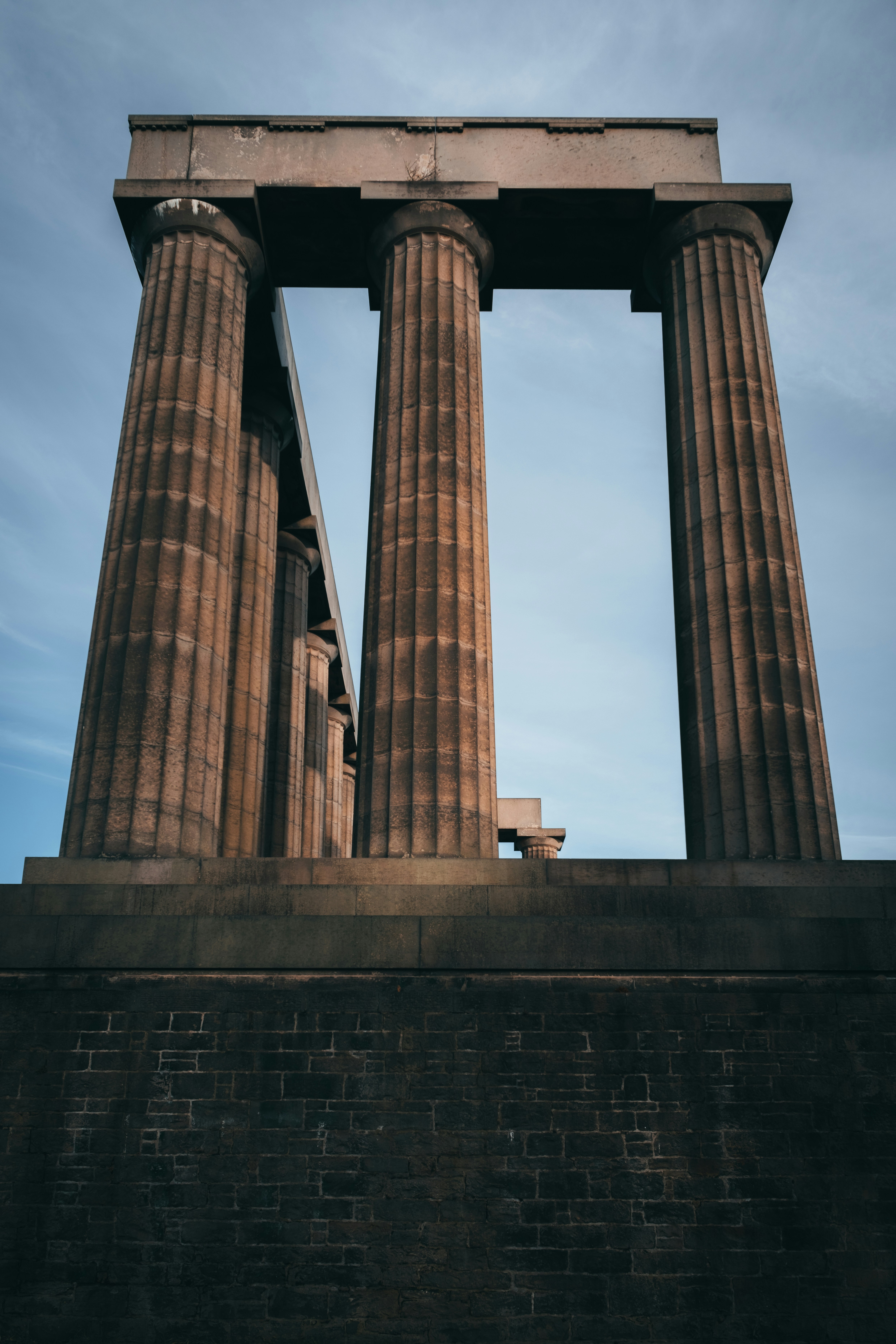 A tall stone structure with two columns on top of it photo – Free Tower ...