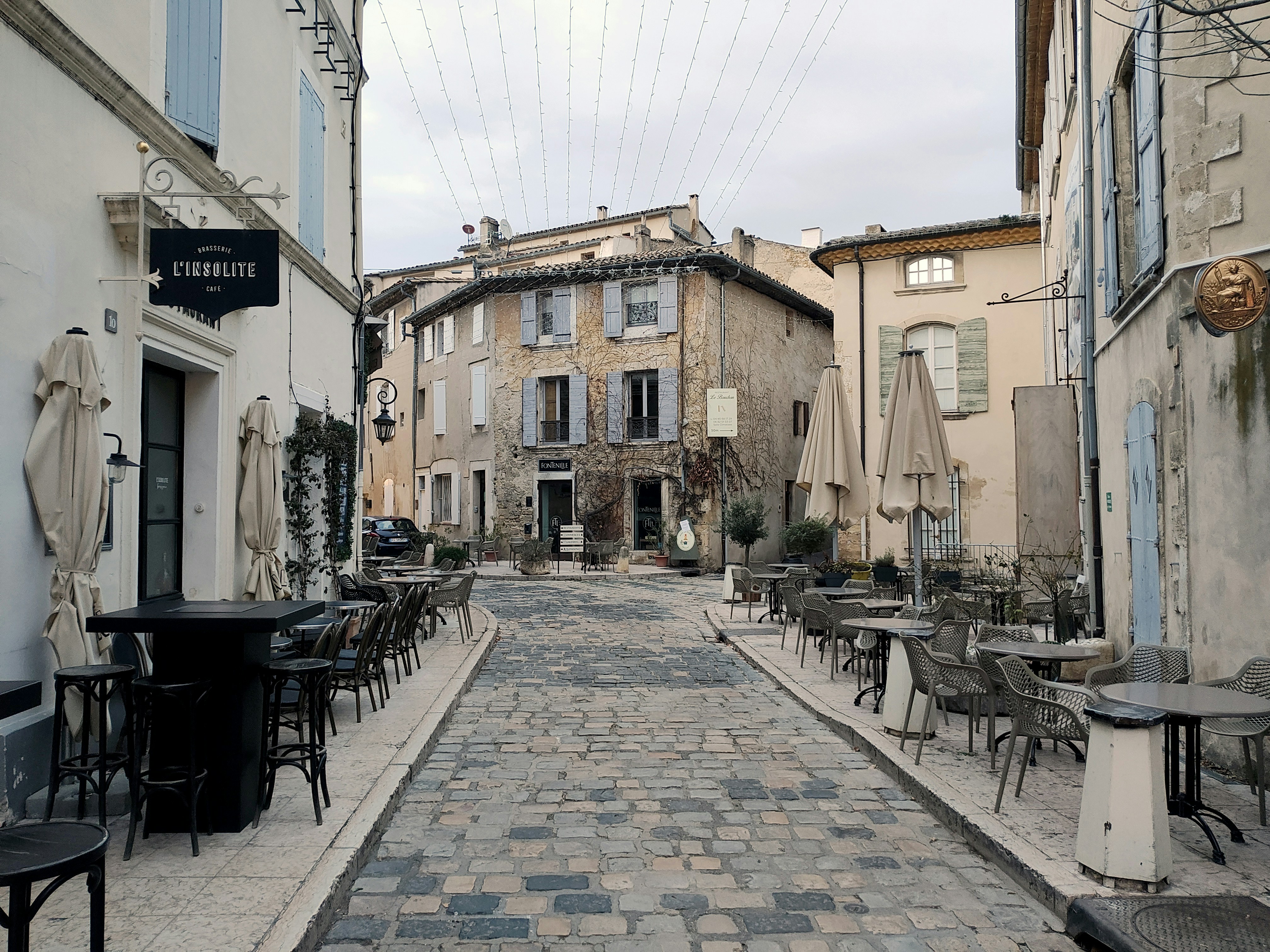 A cobblestone street lined with tables and chairs