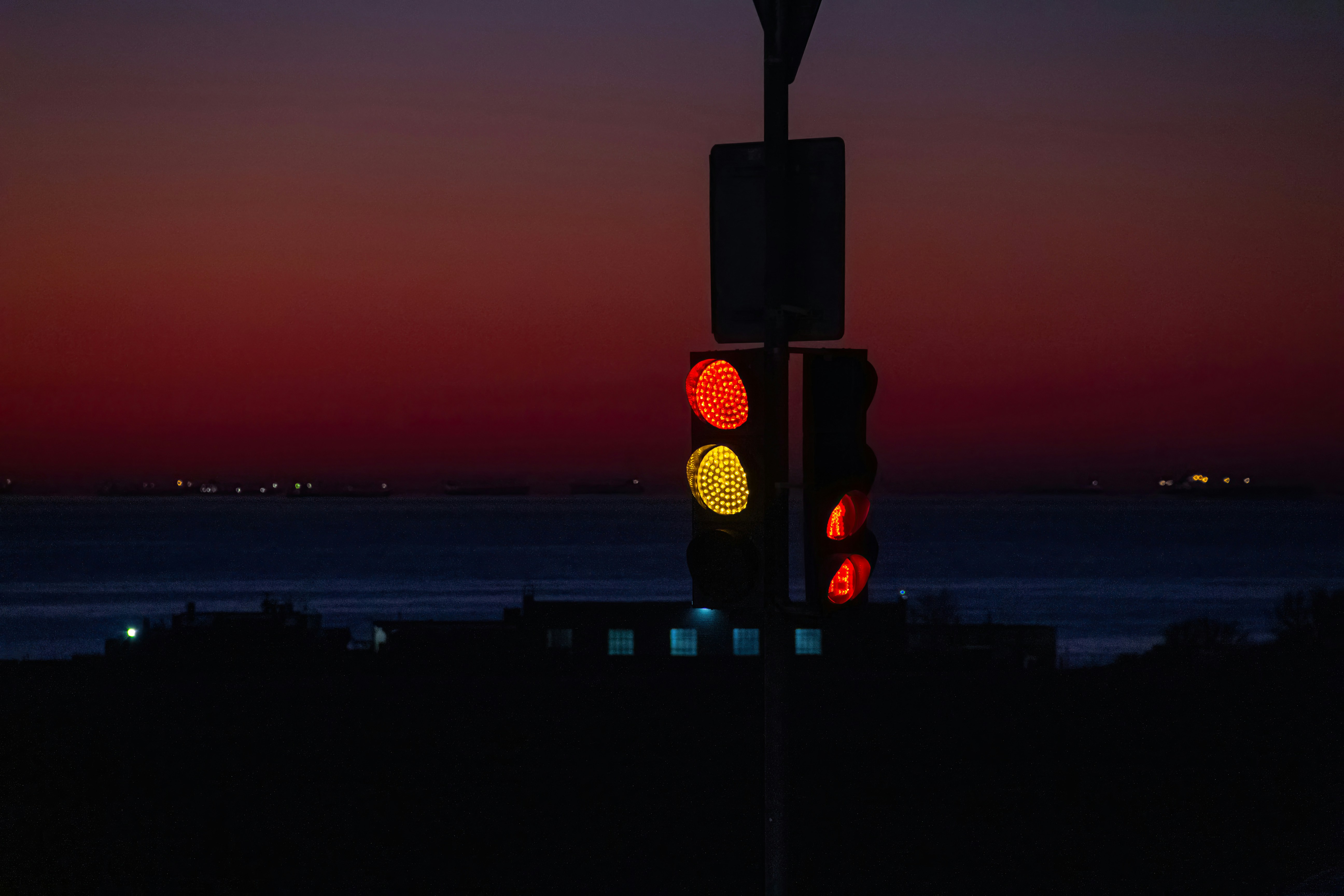A traffic light with the sun setting in the background photo – Free ...