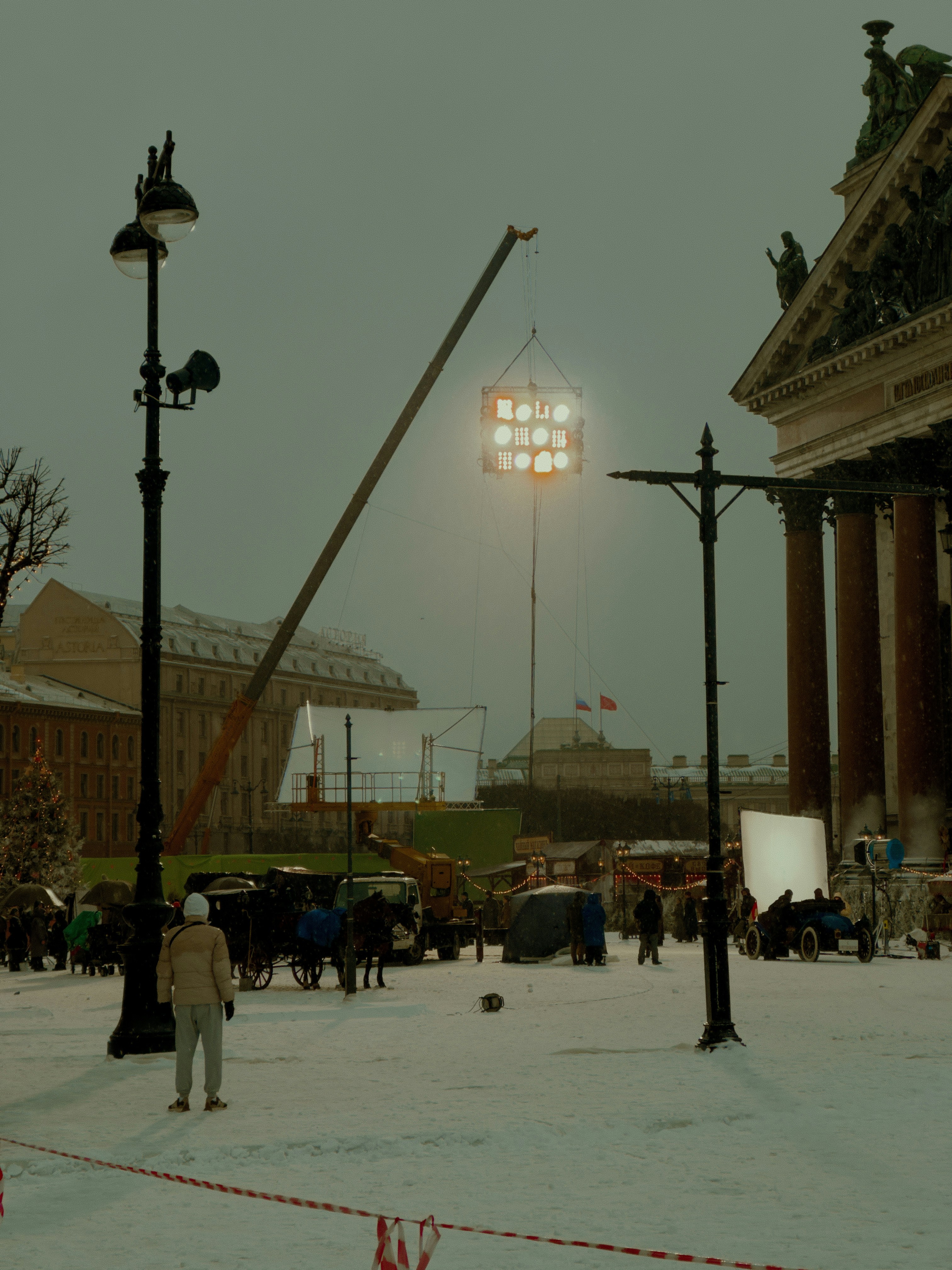 Spotlight Crane Over a Snow-Covered City Square at Dusk