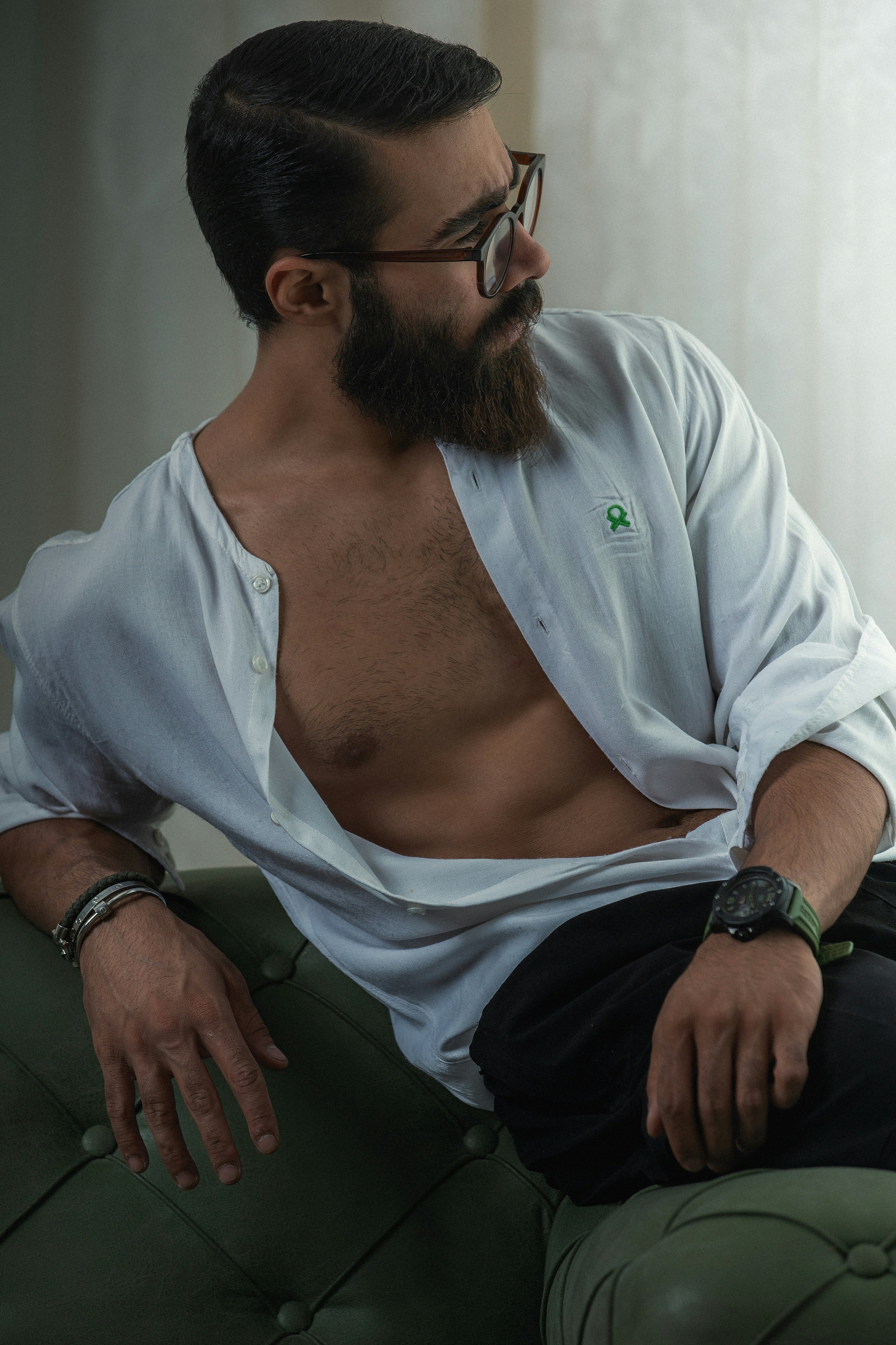 A man with a beard sitting on a green couch photo – Free Portrait Image ...