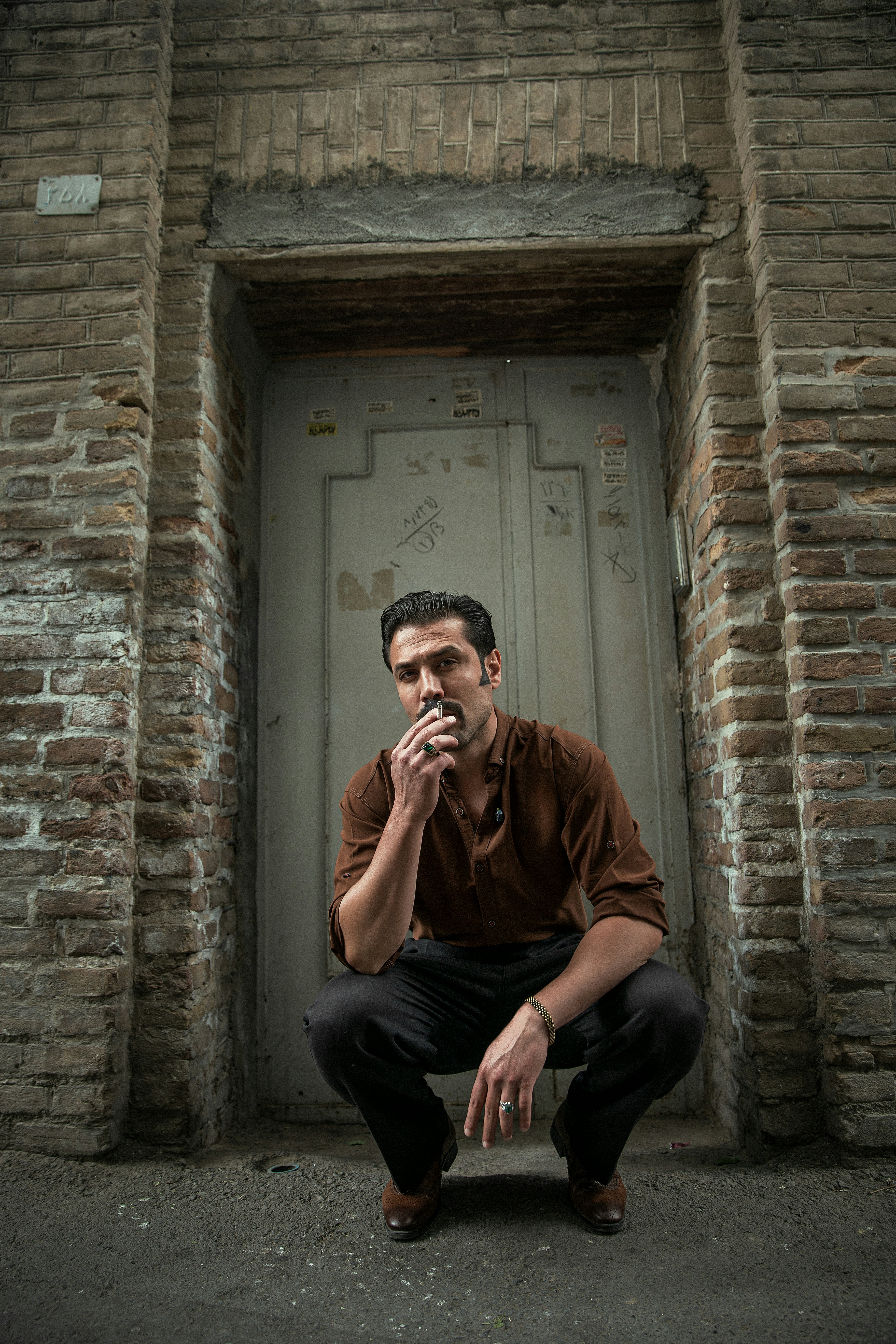 A man squatting down in front of a door photo – Free Portrait Image on ...