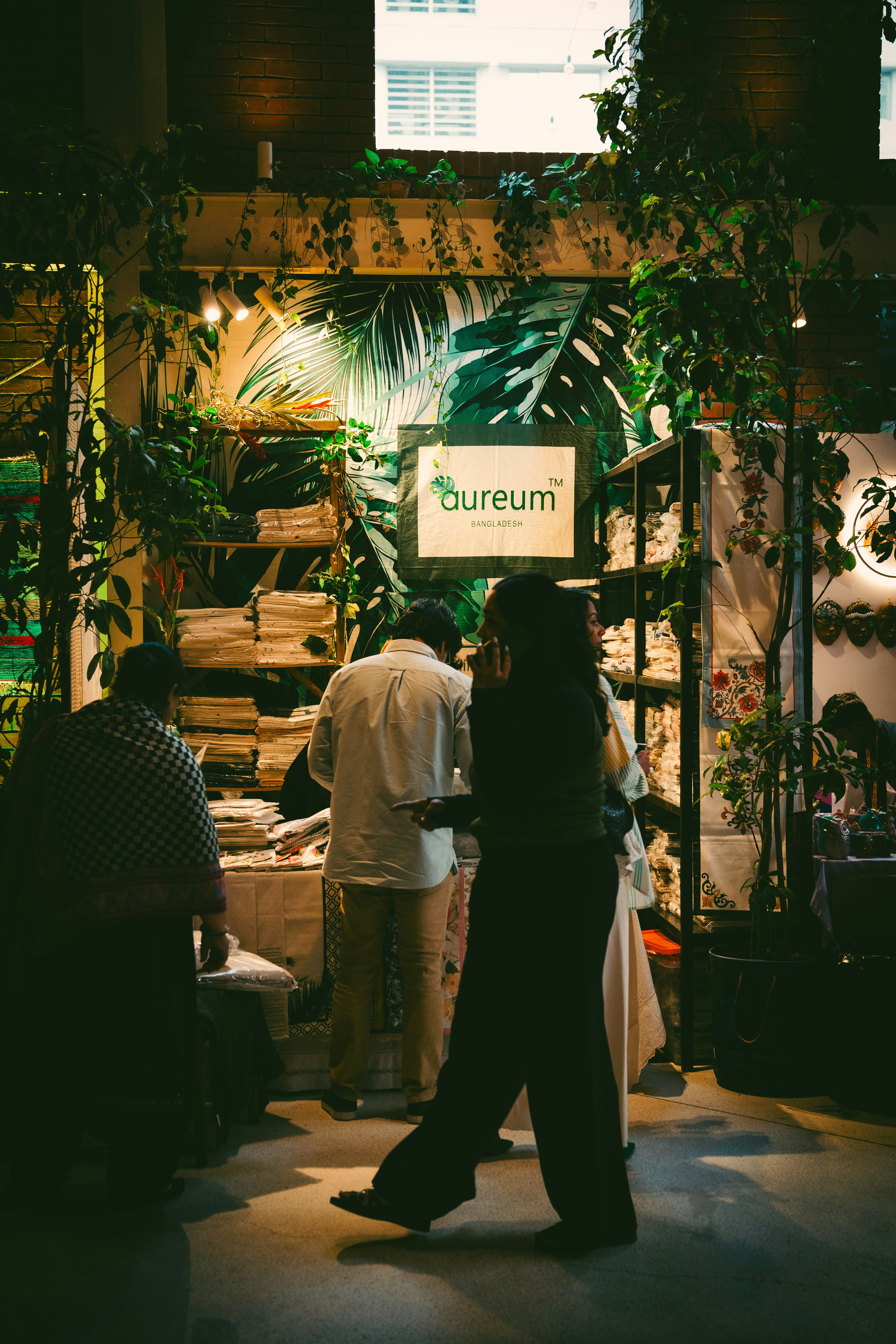 Greenhouse Glow: Shoppers at a Plant-Laden Market Stall