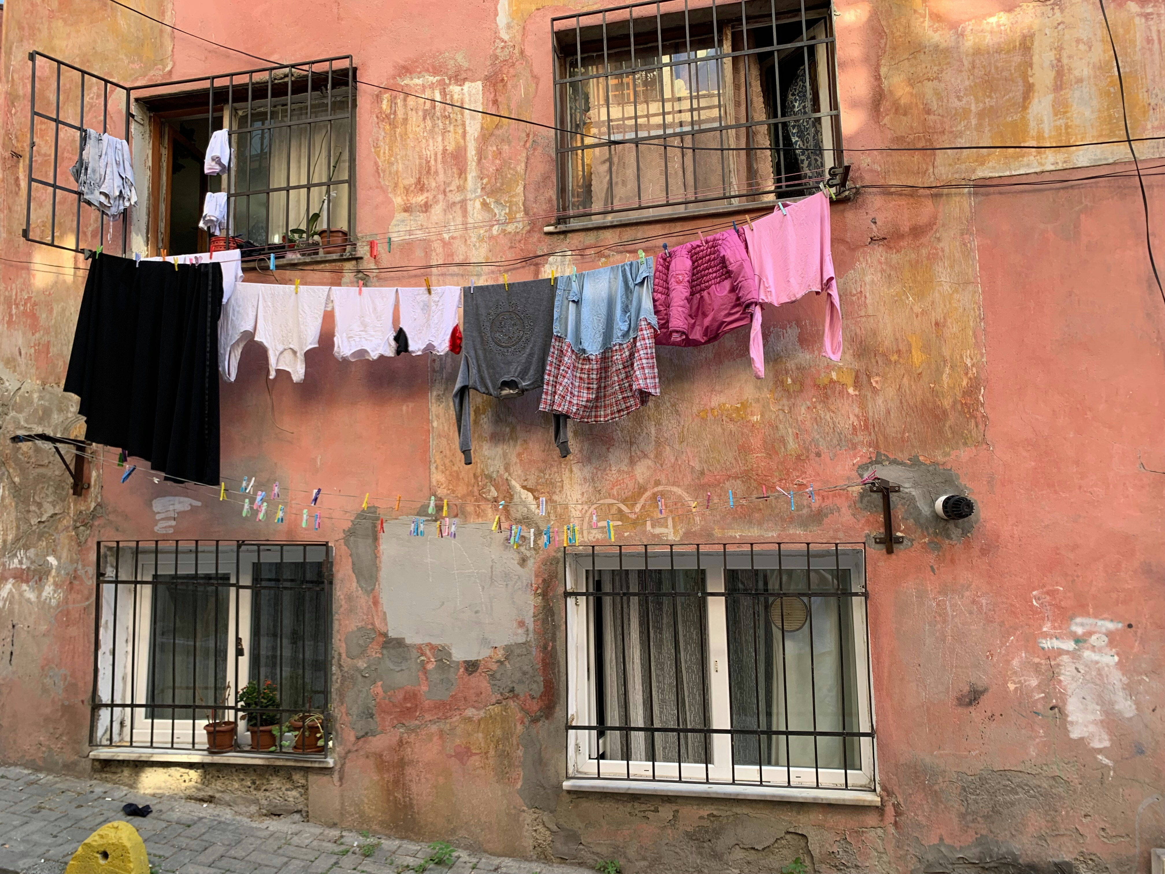 Laundry Lines Across a Weathered Pink Facade: A Quiet City Portrait